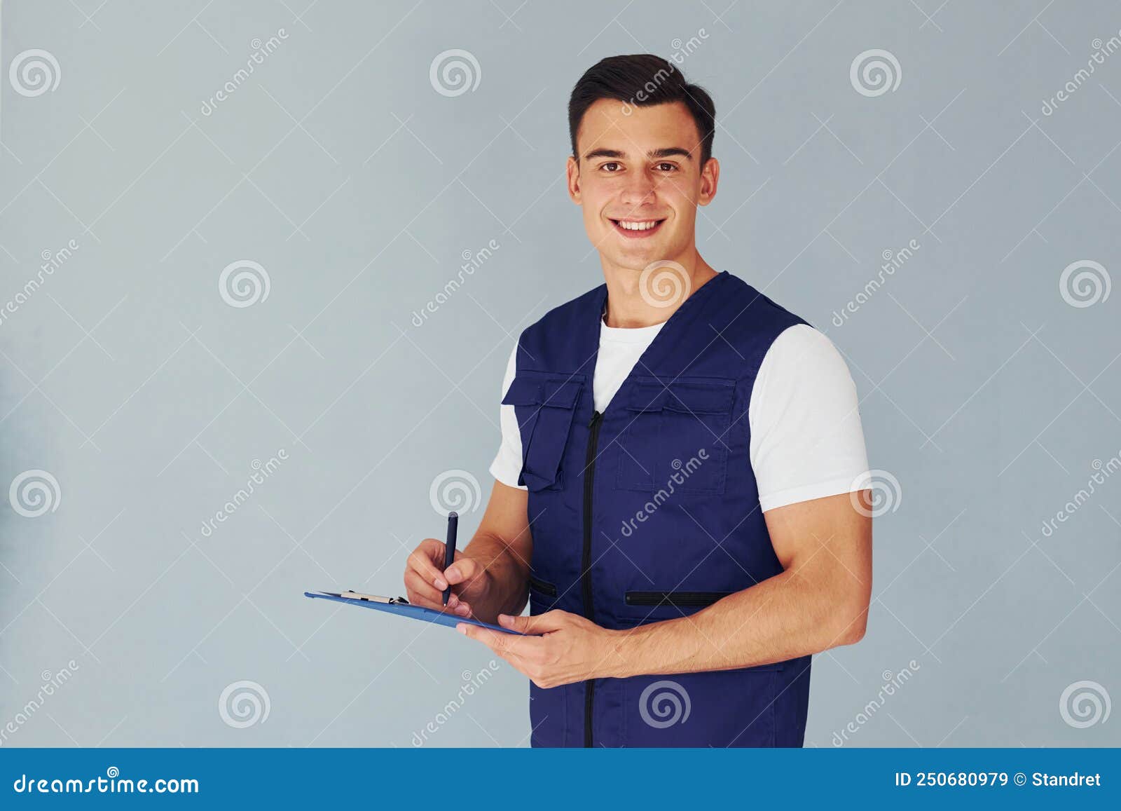 Writes in Notepad. Male Worker in Blue Uniform Standing Inside of ...