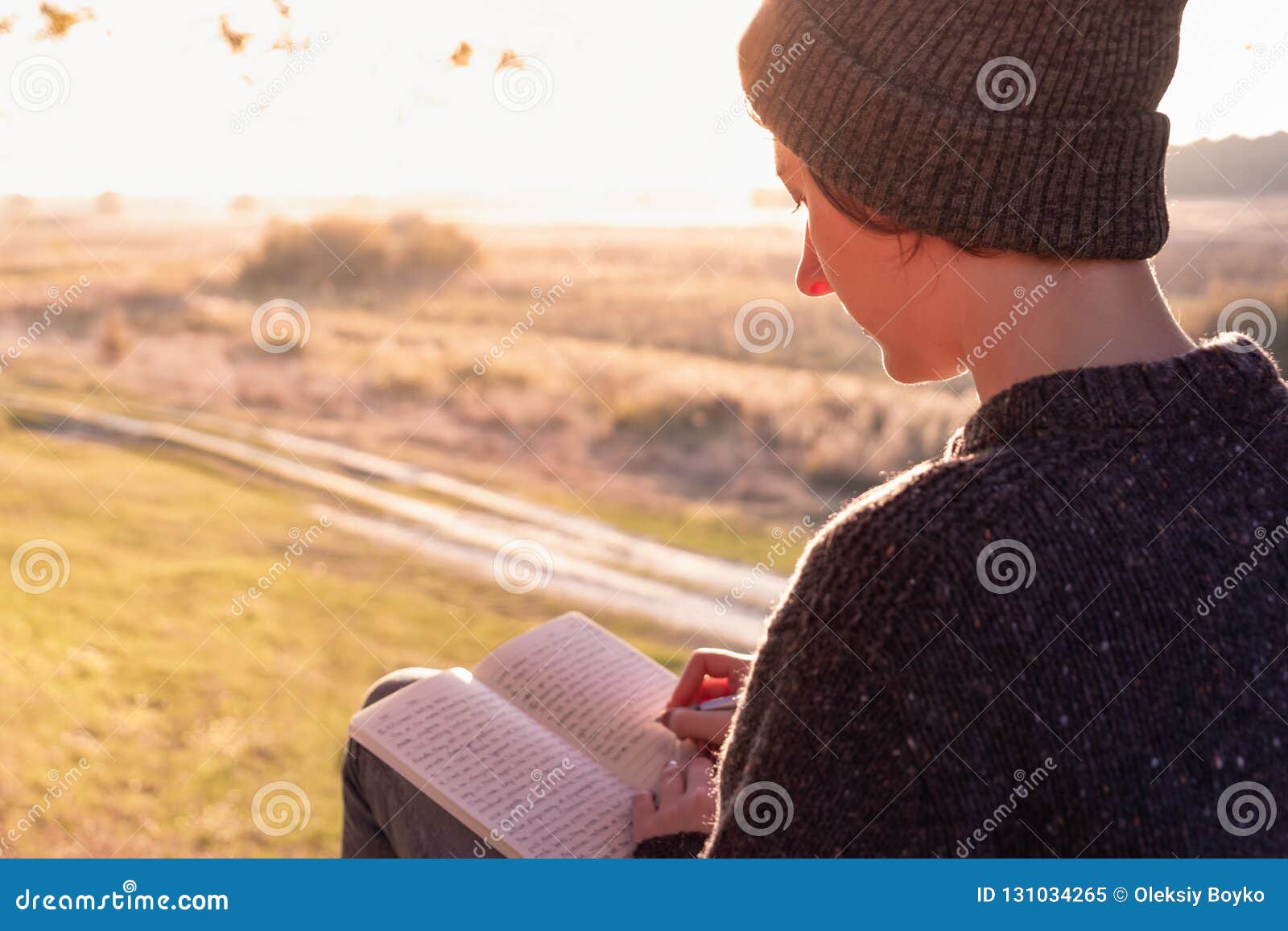 Writing a Diary in Beautiful Nature. Woman Facing Evening Sun Ta Stock ...