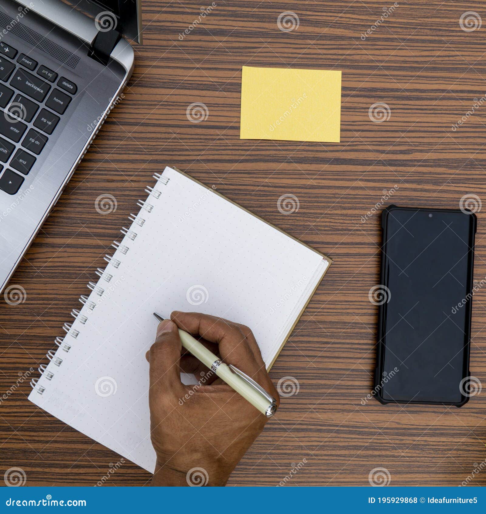 Writing on a Notepad while Working from Home. a Lap Top, a Mobile ...