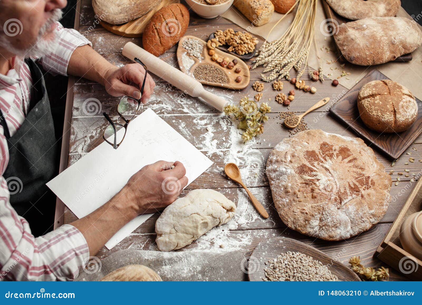 Old Baker Writing Down Old-time Recipe in Bakery Notebook Surrounded by ...