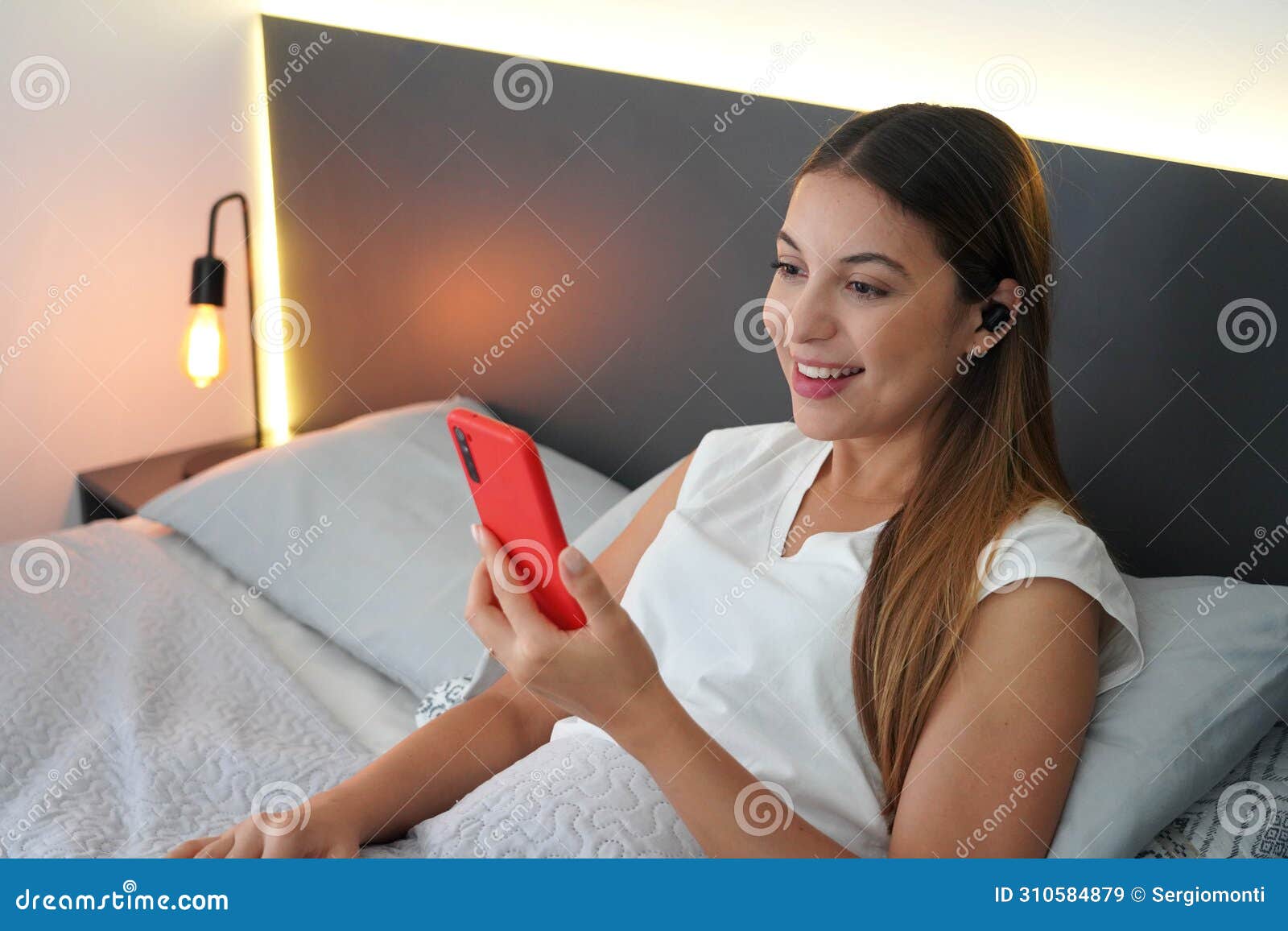Wrong Use of Technological Devices before Sleeping. Smiling Young Woman ...