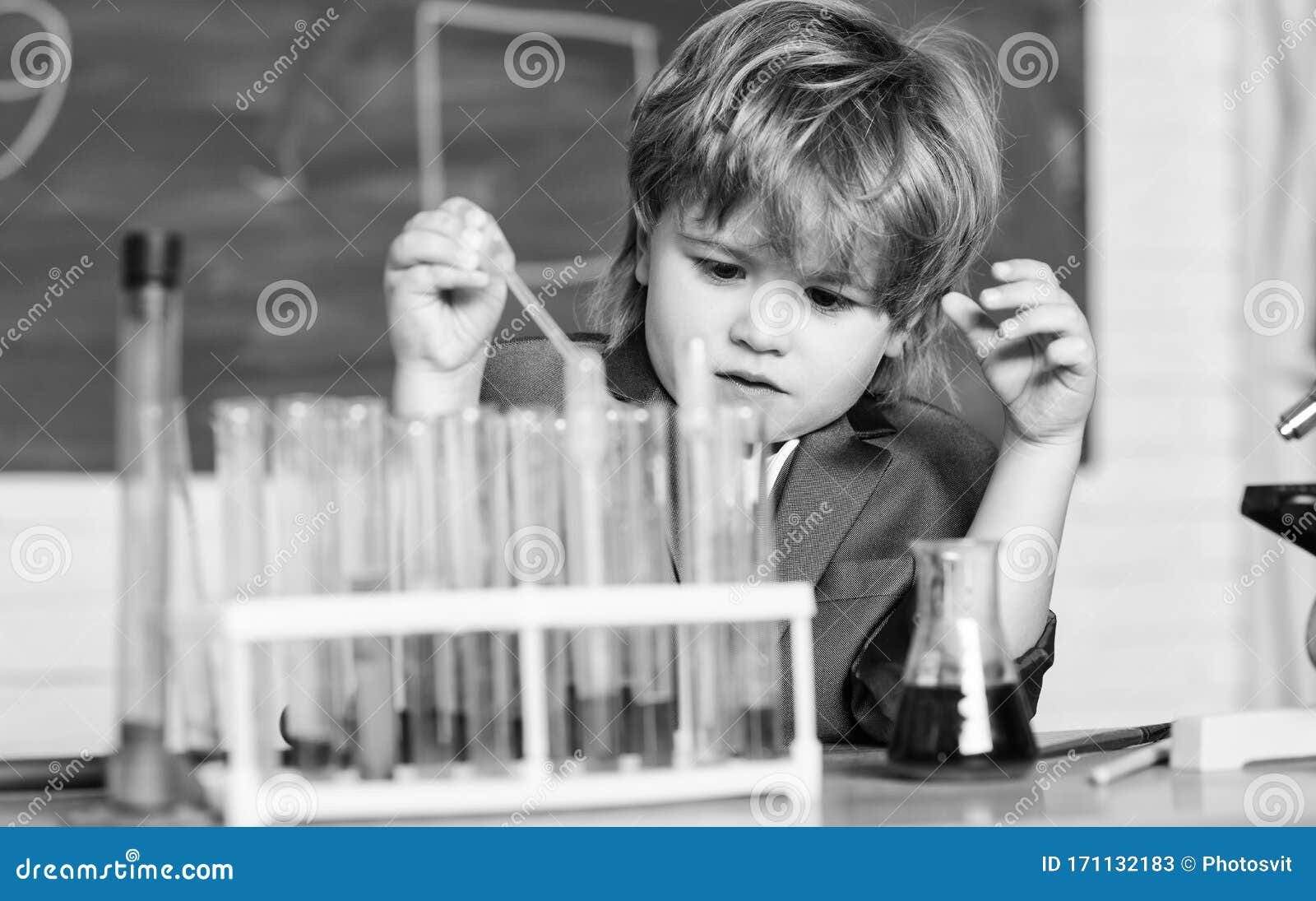 Wunderkind Experimenting with Chemistry. Boy Use Microscope Test Tubes ...
