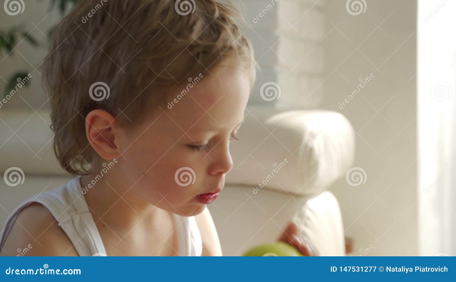 6 Year Old Boy Eating Green Apple and Try Pull Out Baby Teeth Stock ...