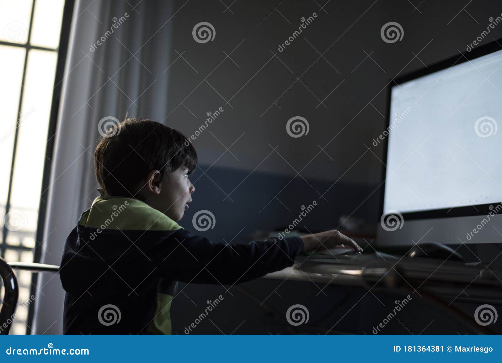 4 Year Old Boy Handles the Computer in a Dark Environment at Home Stock ...