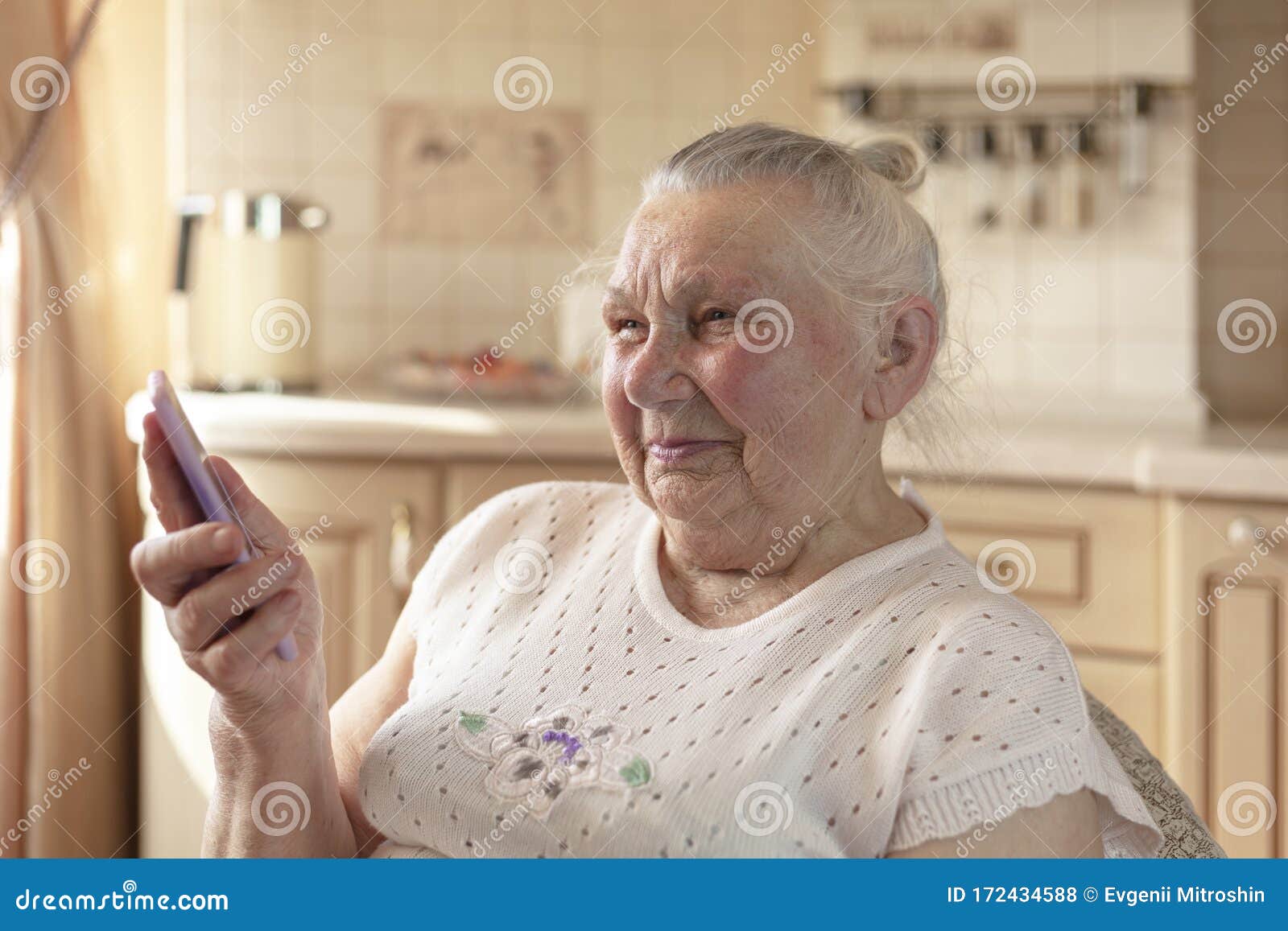 61 Year Old Grandmother With An Amused Face Listens To An Entertaining