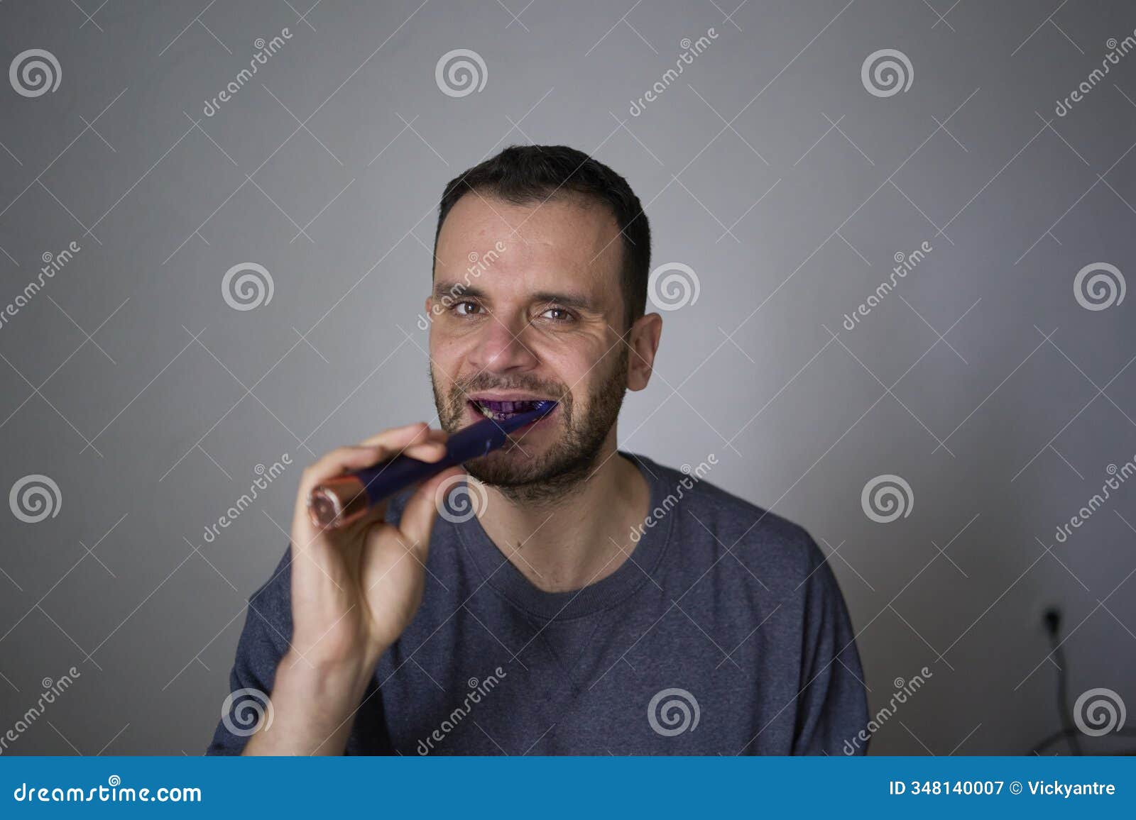 A 30-year-old Man Brushes His Teeth with Purple Toothpaste Using an ...