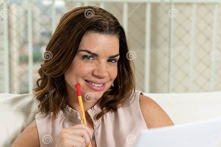 38 Year Old Woman In Her Home Office Sitting On The Couch Making Notes