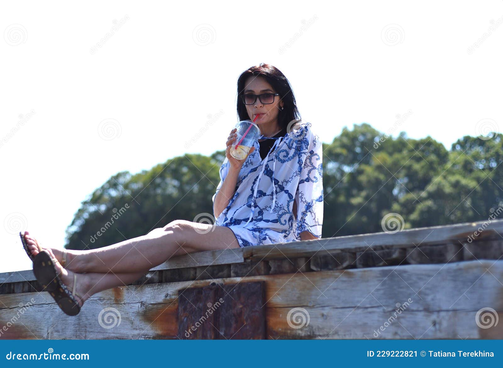 45 Years Old Russian Woman Drinking Lemonad And Sitting On Pier Stock