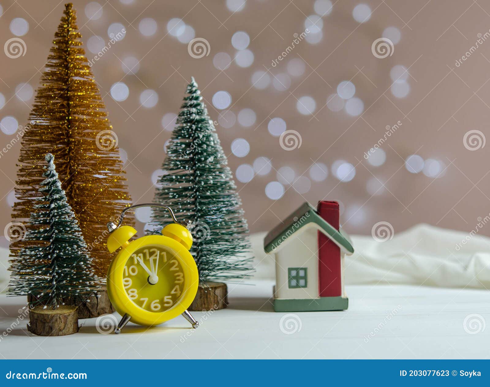 Yellow Alarm Clock, Small House and Christmas Trees on the Table Stock ...