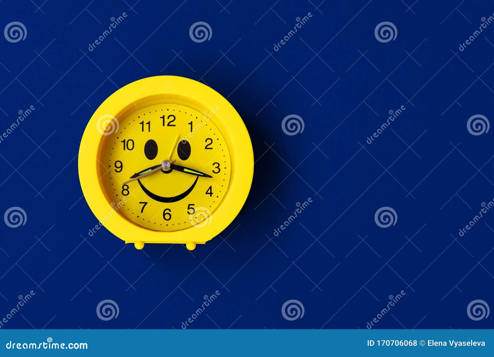 Yellow Alarm Clock with a Smiling Smiley Face on Blue Background Stock ...