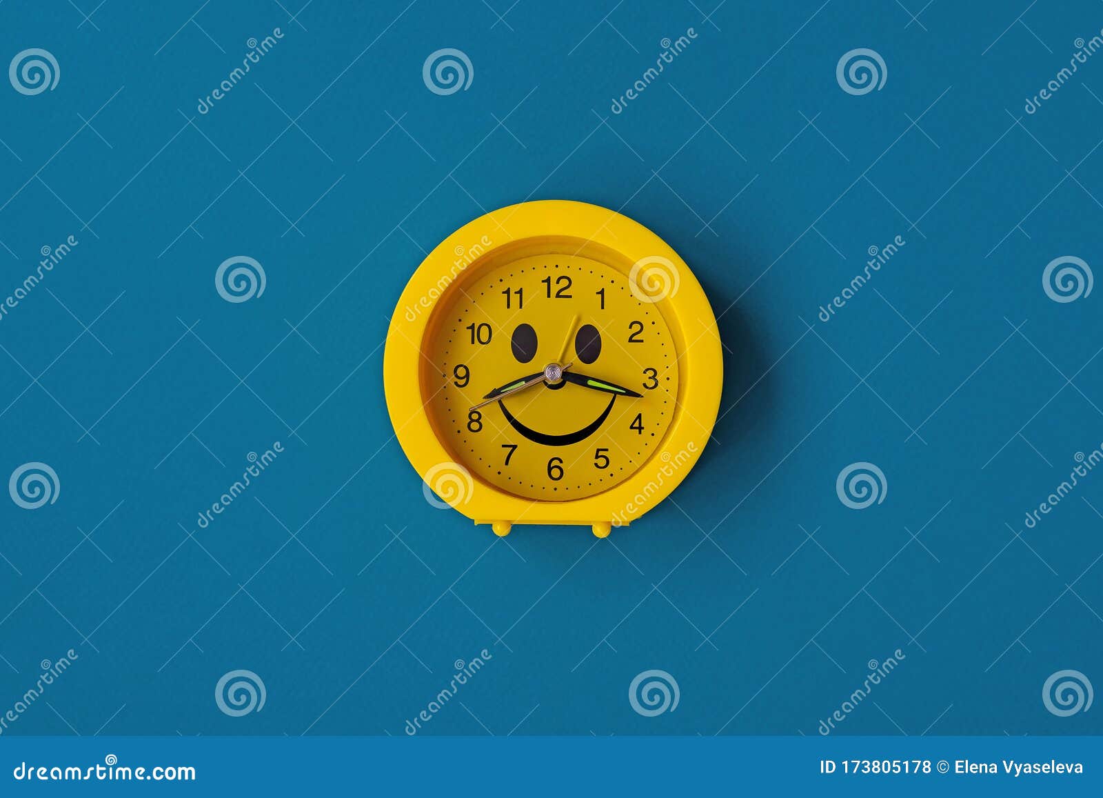 Yellow Alarm Clock with a Smiling Smiley Face on Blue Background Stock ...