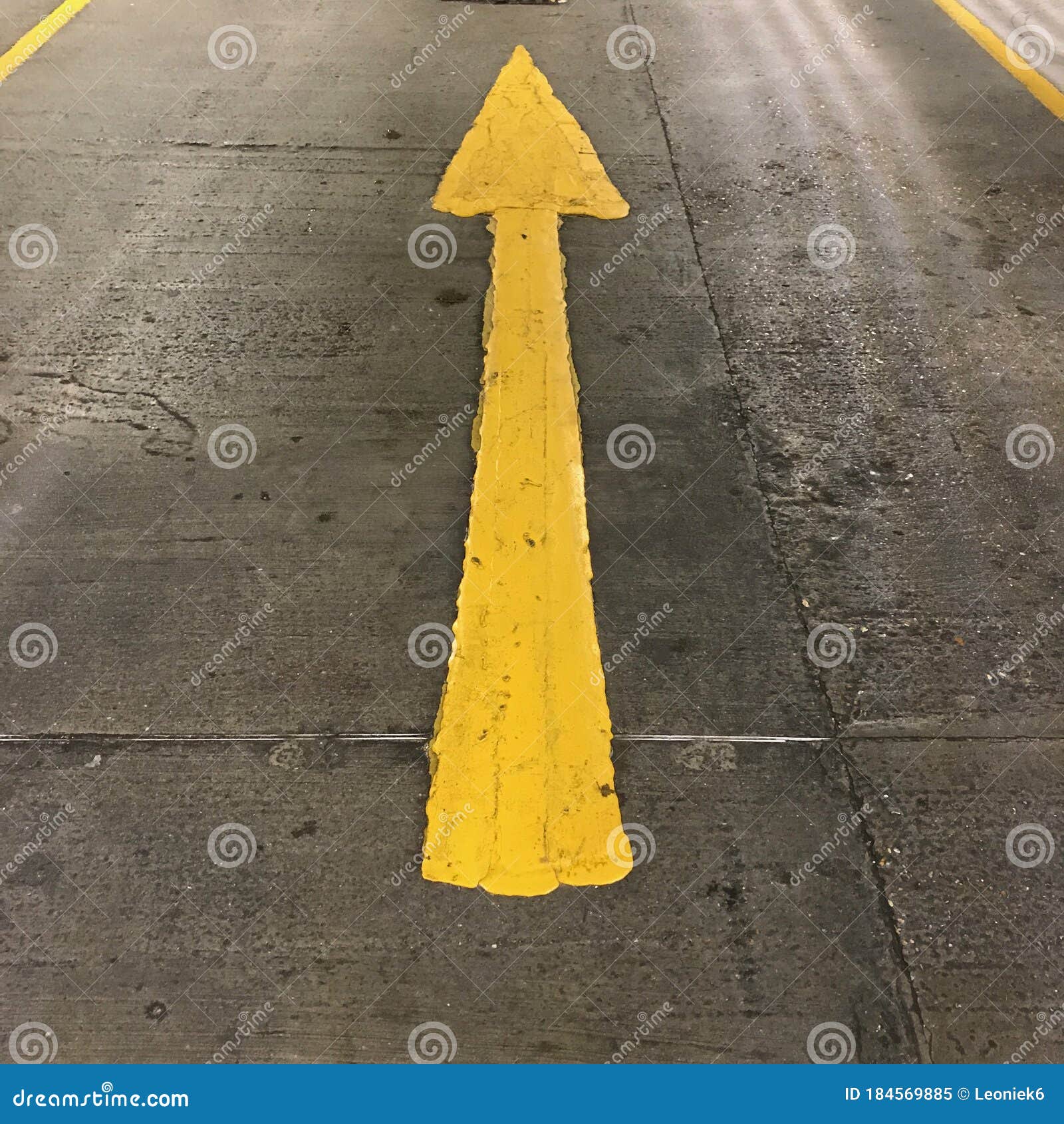 Yellow Arrow on the Floor of a Parking Lot Stock Image - Image of ...