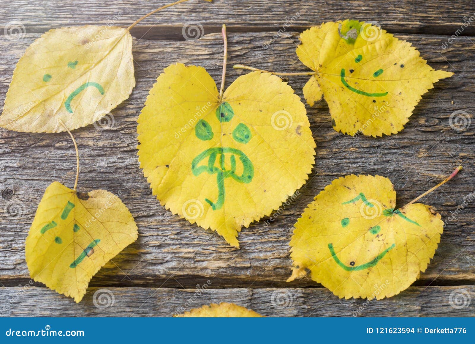 Yellow Autumn Leaves with Smiley Patterns on Wooden Background. Stock ...