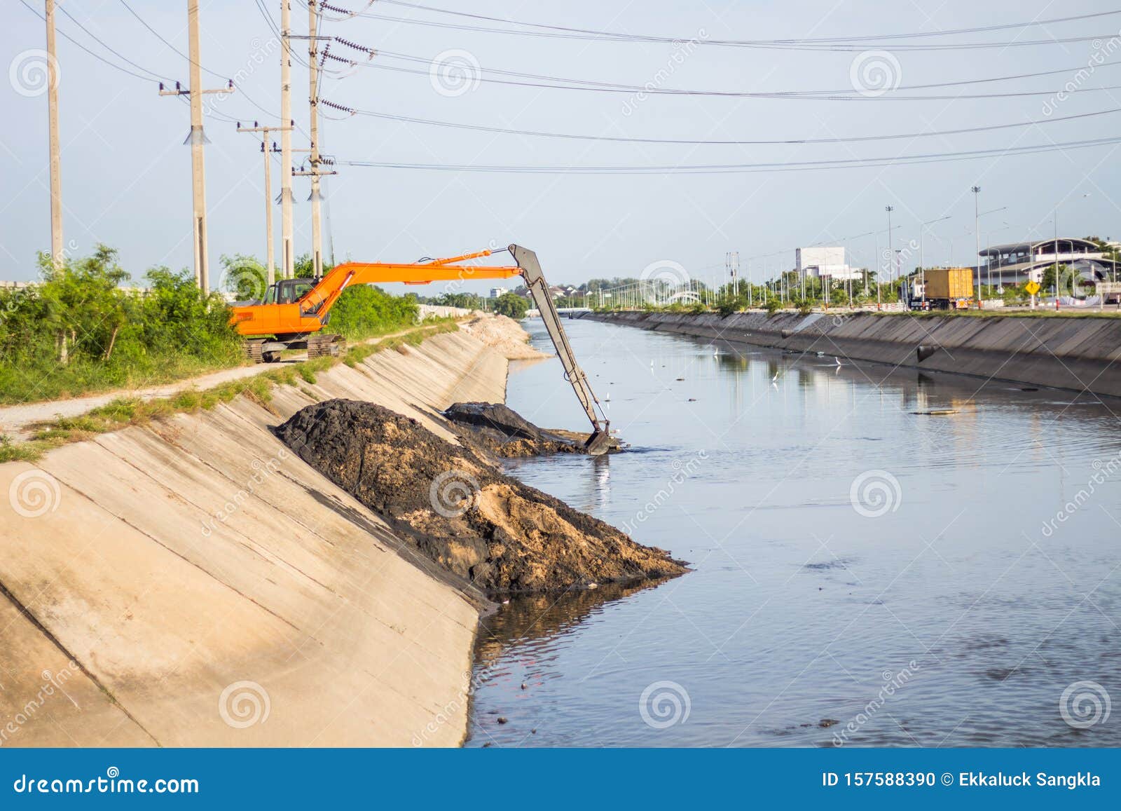 The Yellow Backhoe is Working at the River Pier To Clear the Mud of ...