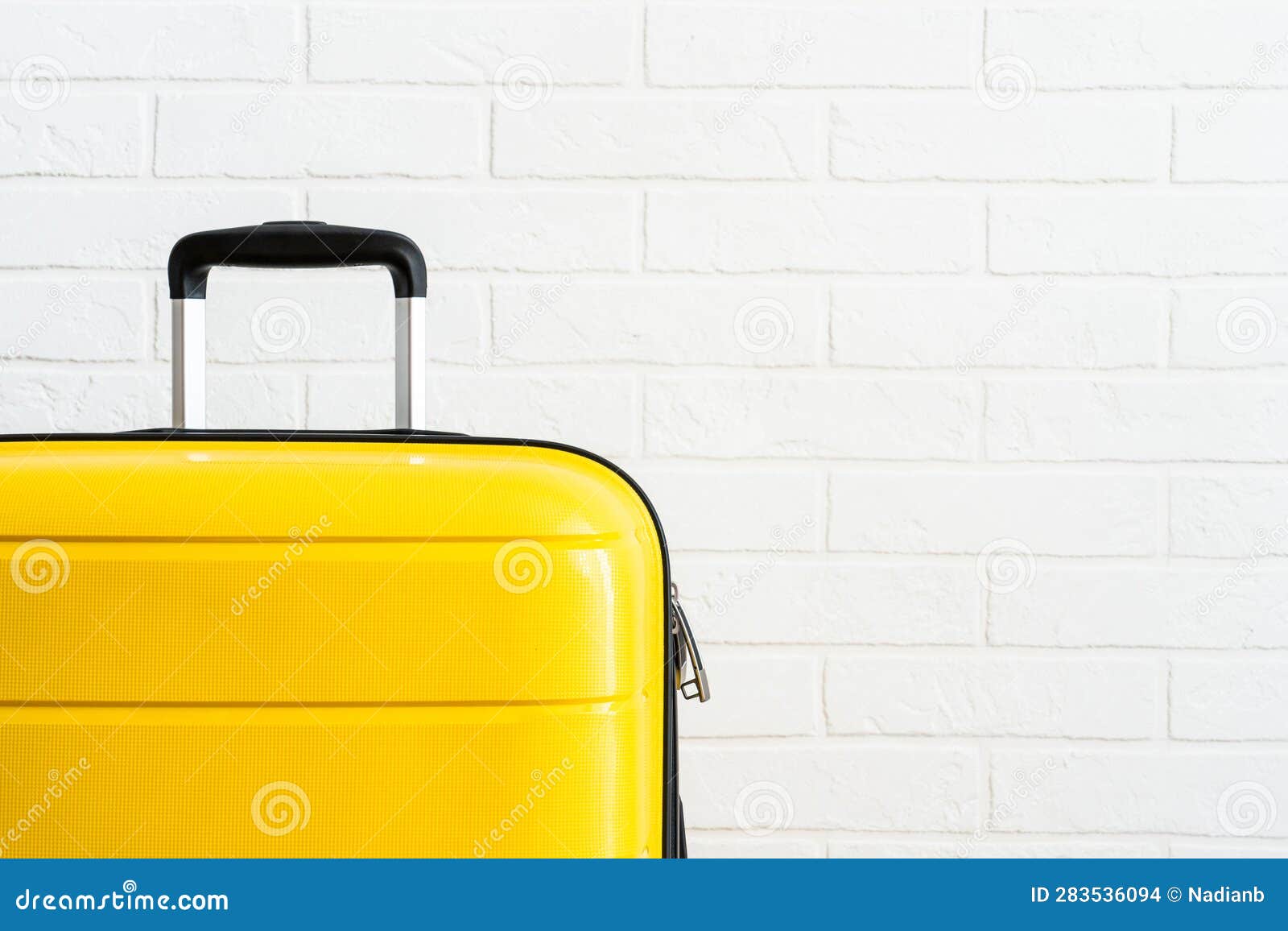Yellow Baggage Near White Brick Wall. Stock Photo - Image of baggage ...