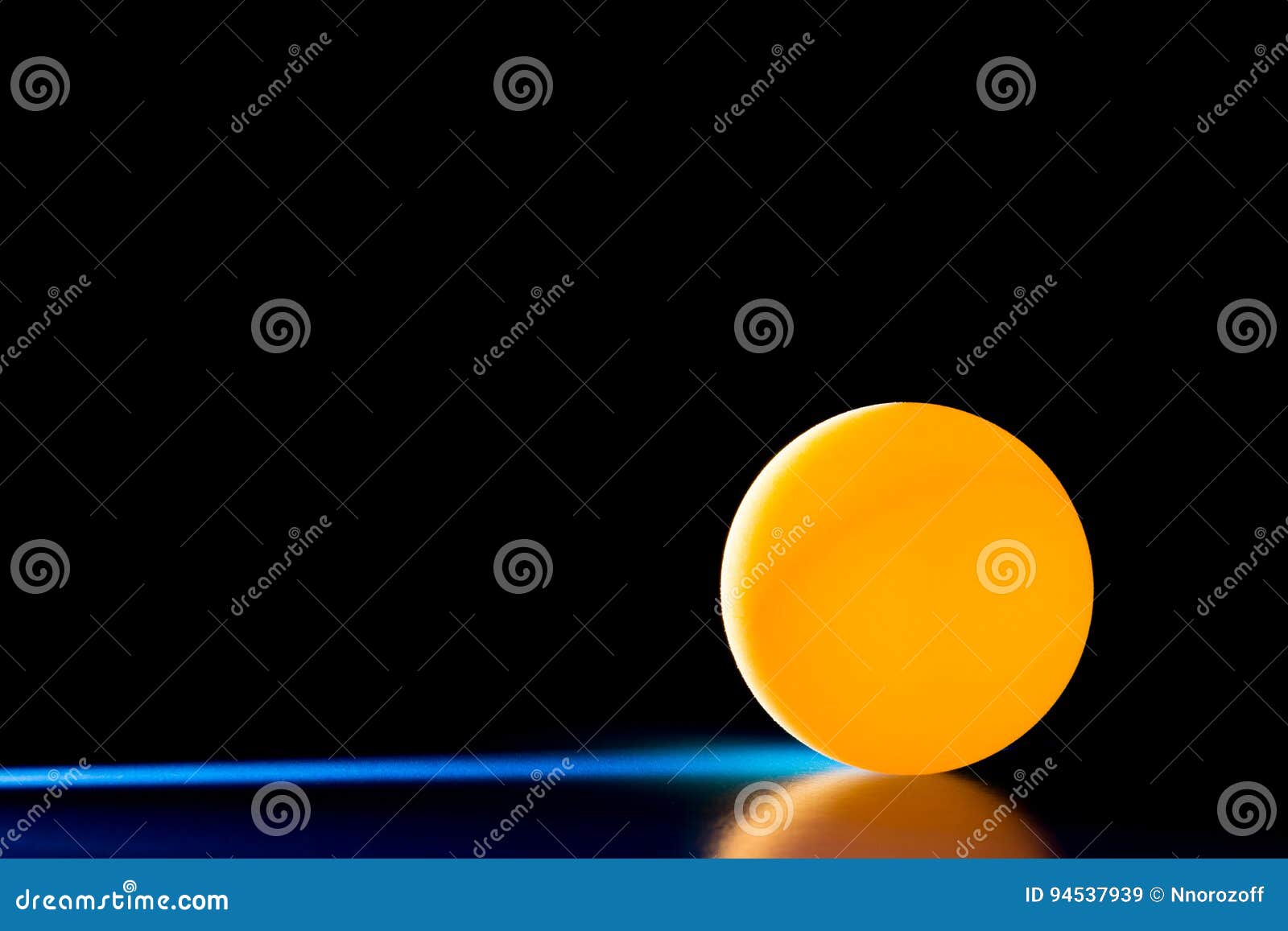 Yellow Ball on a Blue Dark Background Illuminated by a Side Beam of ...