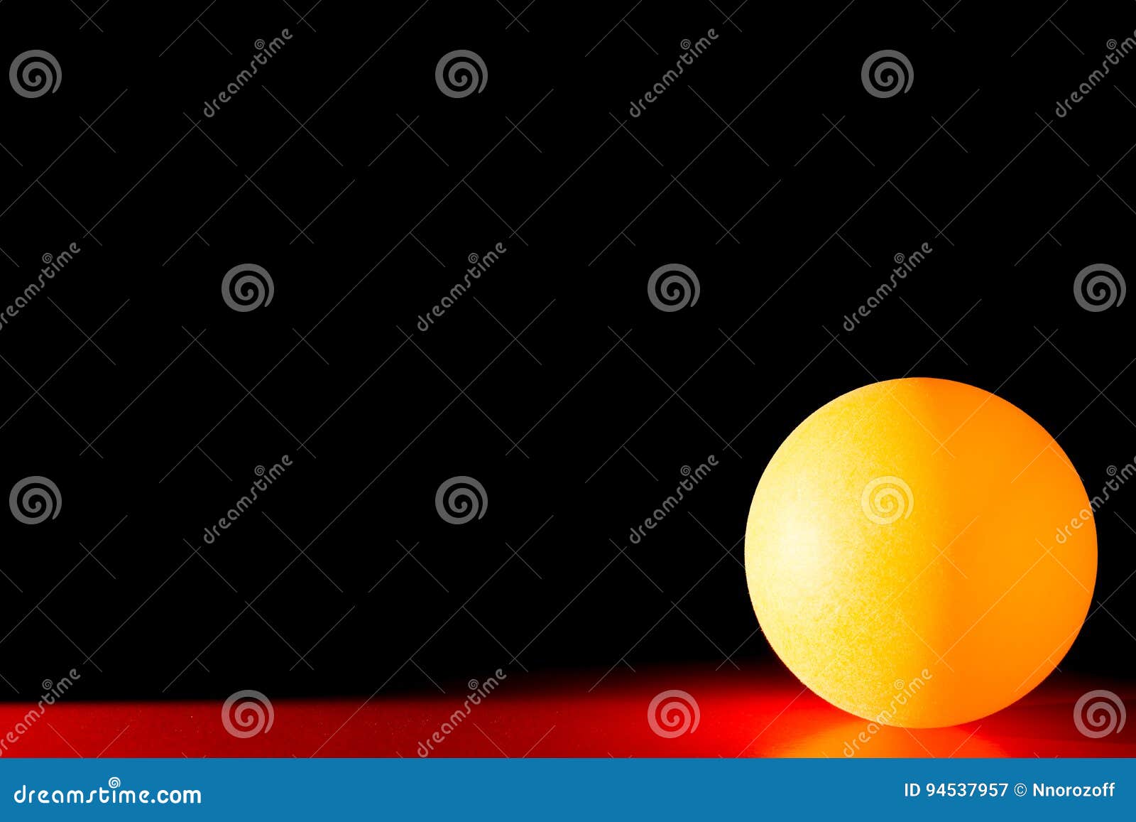 Yellow Ball on a Red Dark Background Illuminated by a Side Beam of ...