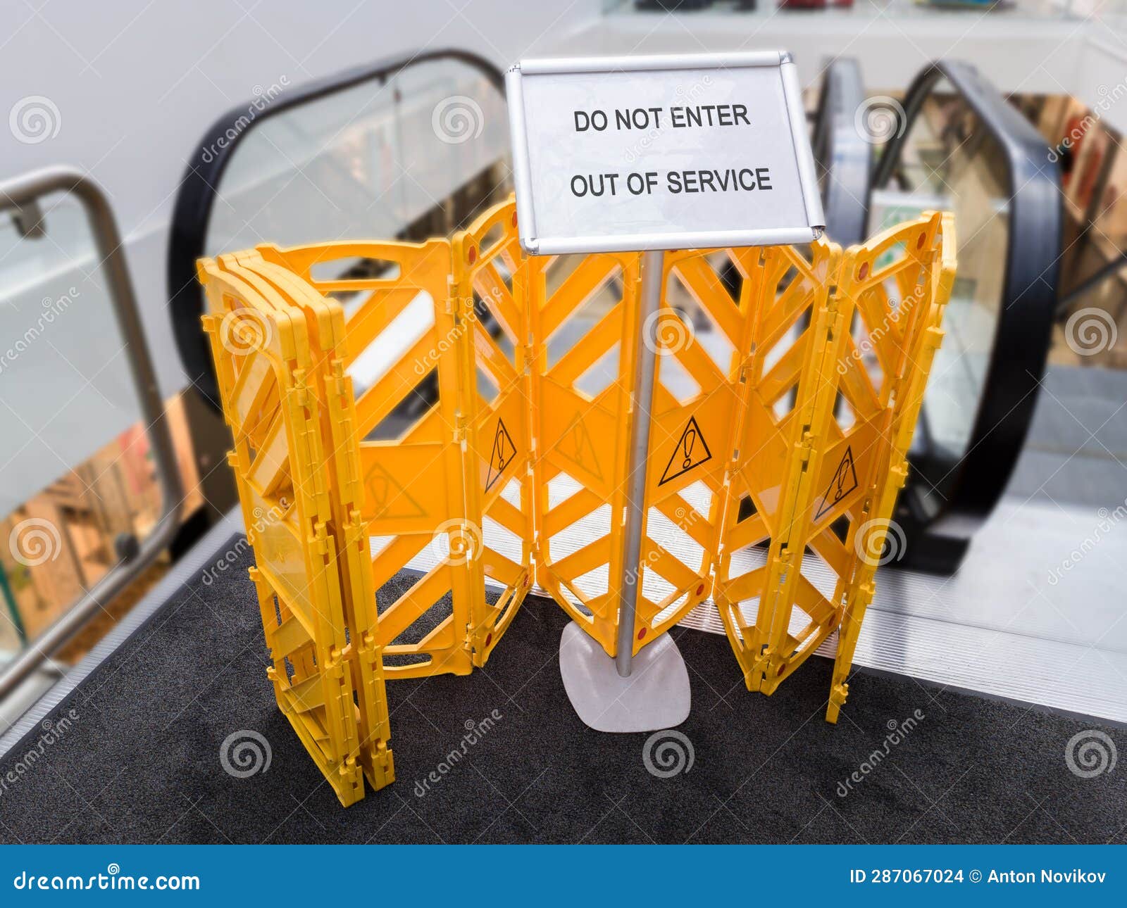 A Yellow Barrier and a Warning Sign in Front of a Broken Escalator ...