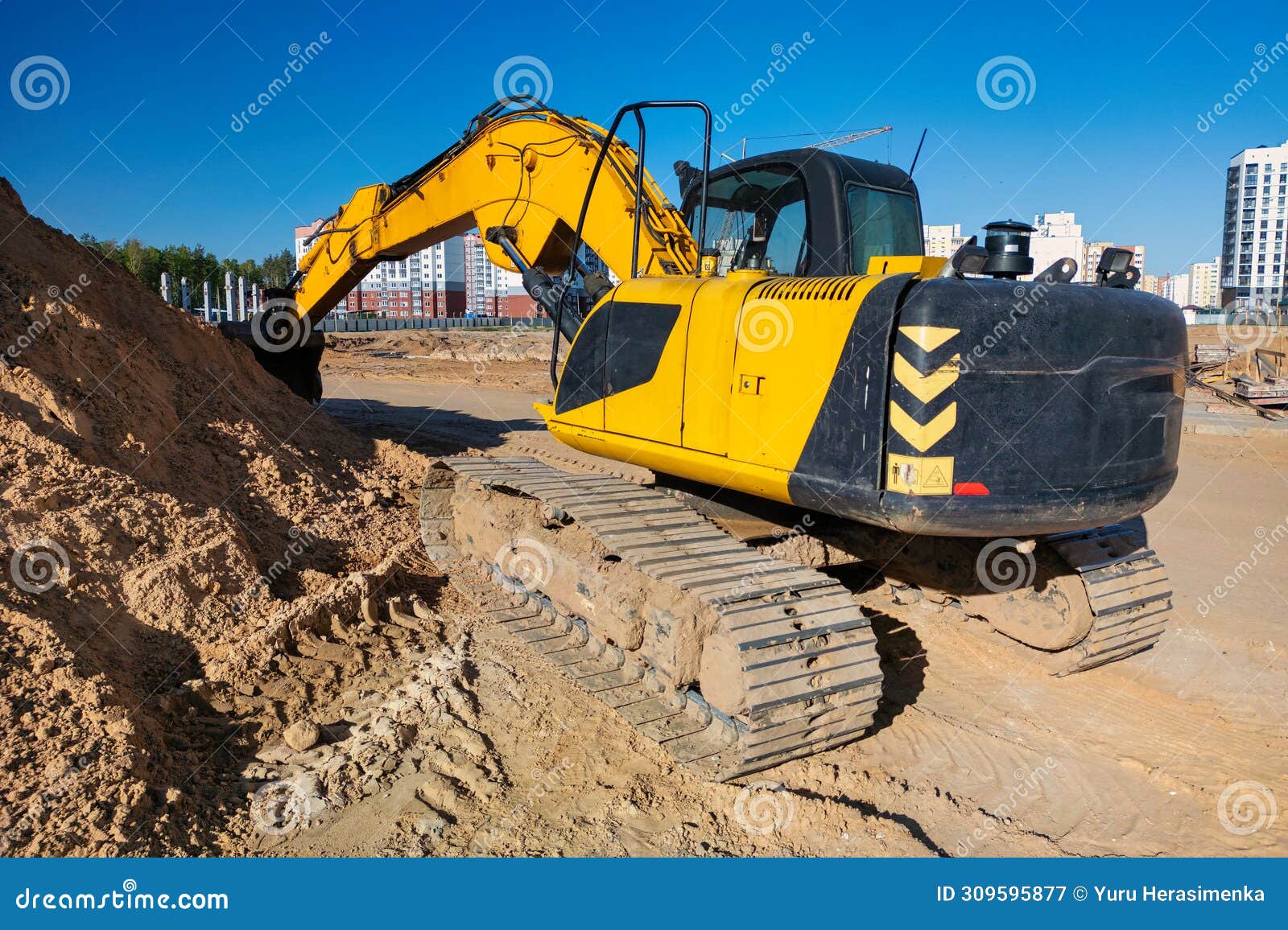 A Yellow and Black Bulldozer Actively Digging into a Pile of Dirt at a ...