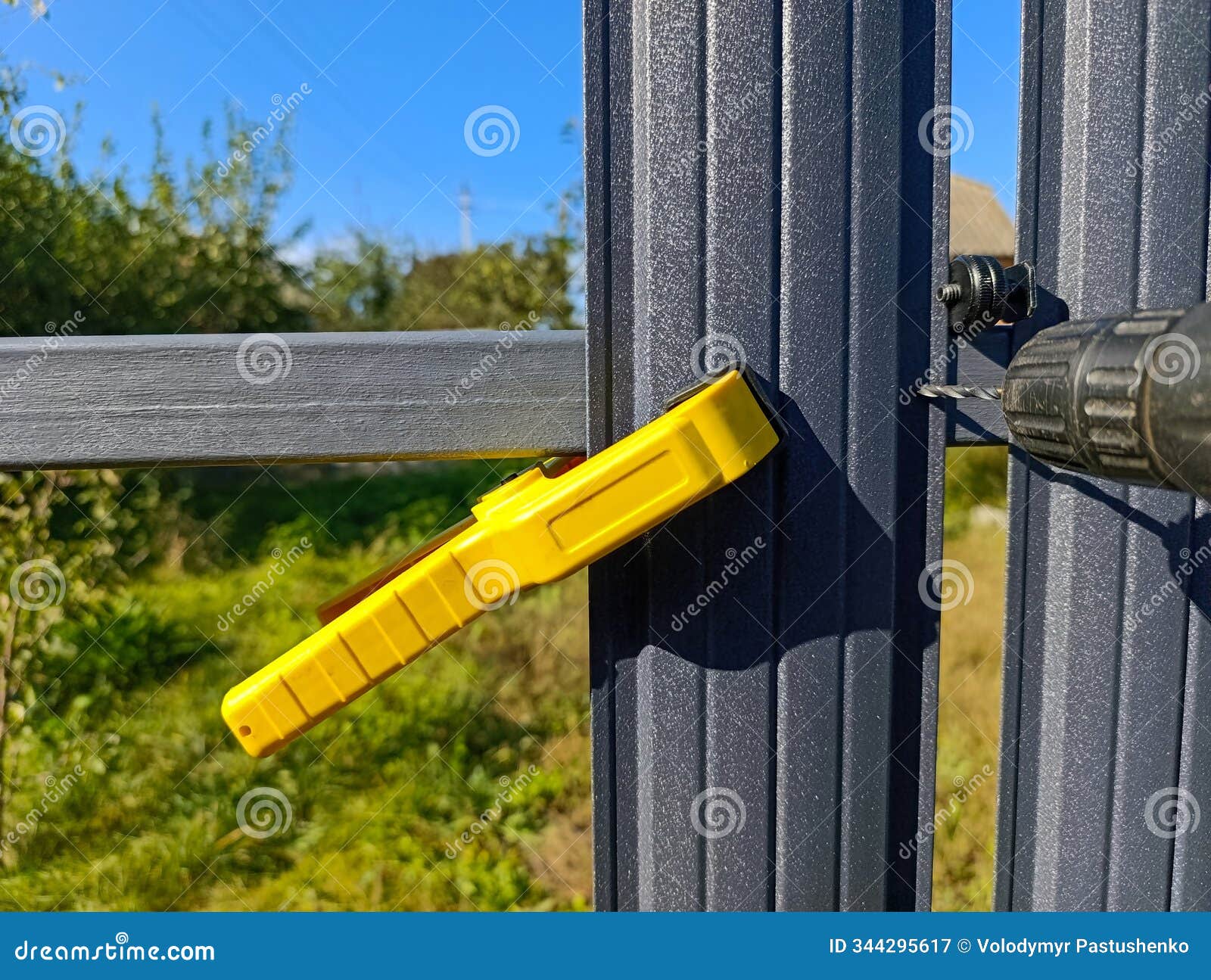 A Yellow and Black Tool is Attached To a Metal Gate Stock Image - Image ...