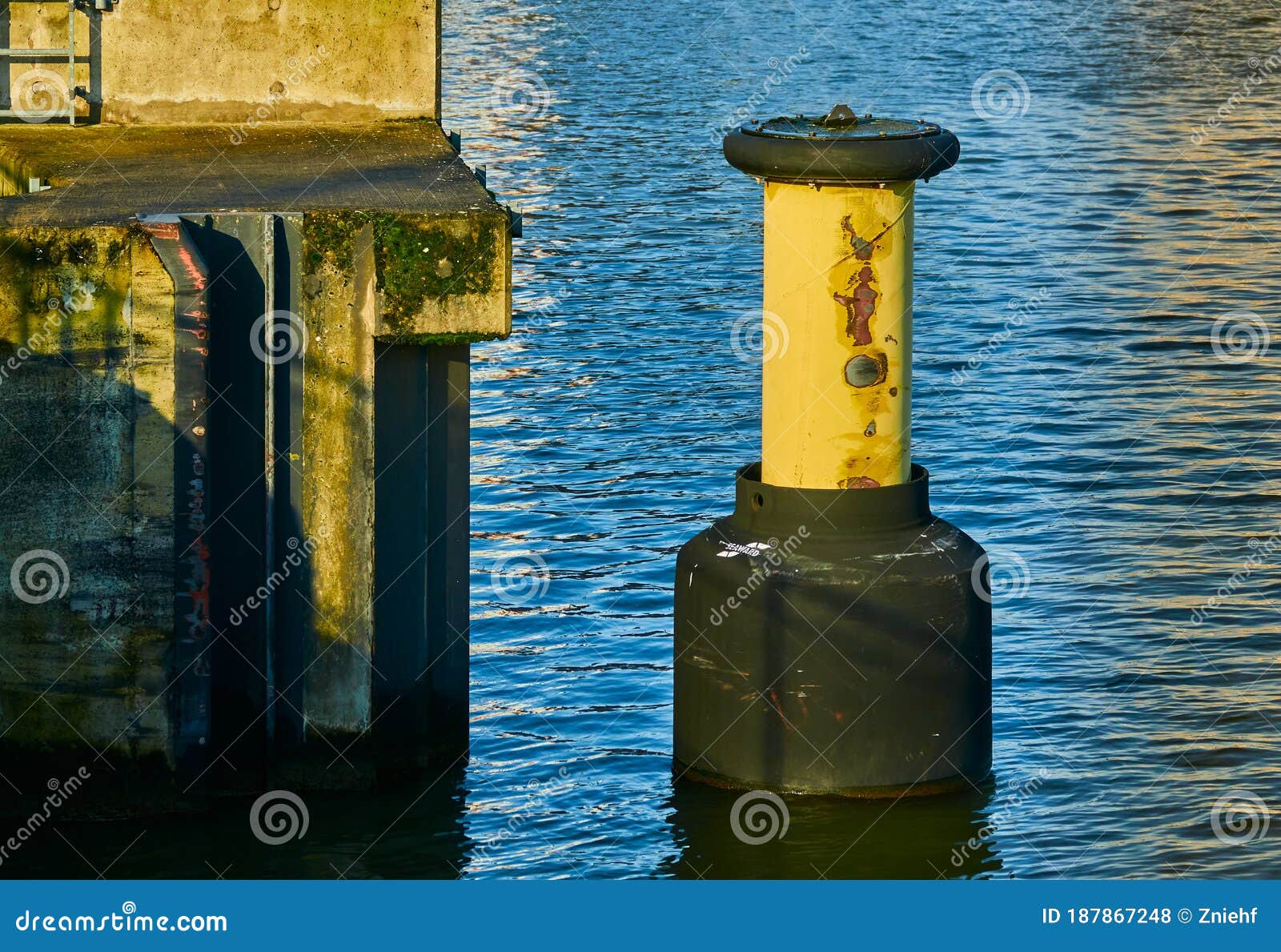 Yellow Bollard with Black Foot in the Water of the Harbour Basin Stock ...