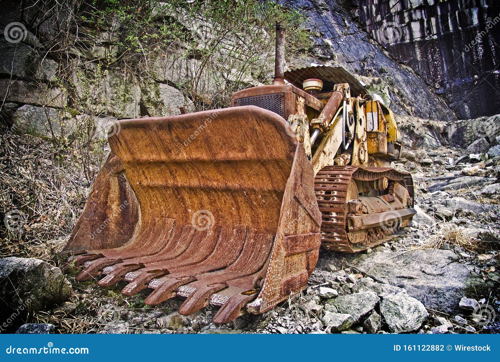 Yellow Bulldozer on a Rocky Surface Near a Cliff Stock Photo - Image of ...