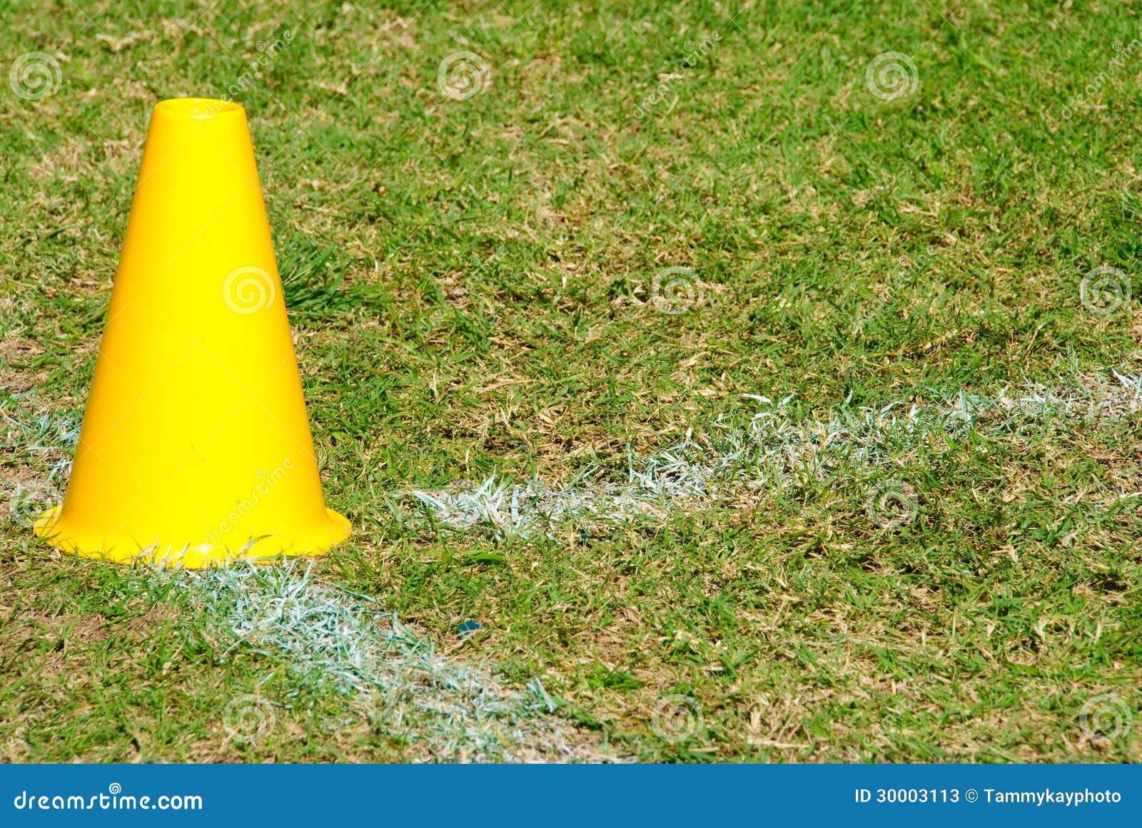 Yellow cone on grass field stock image. Image of marker - 30003113