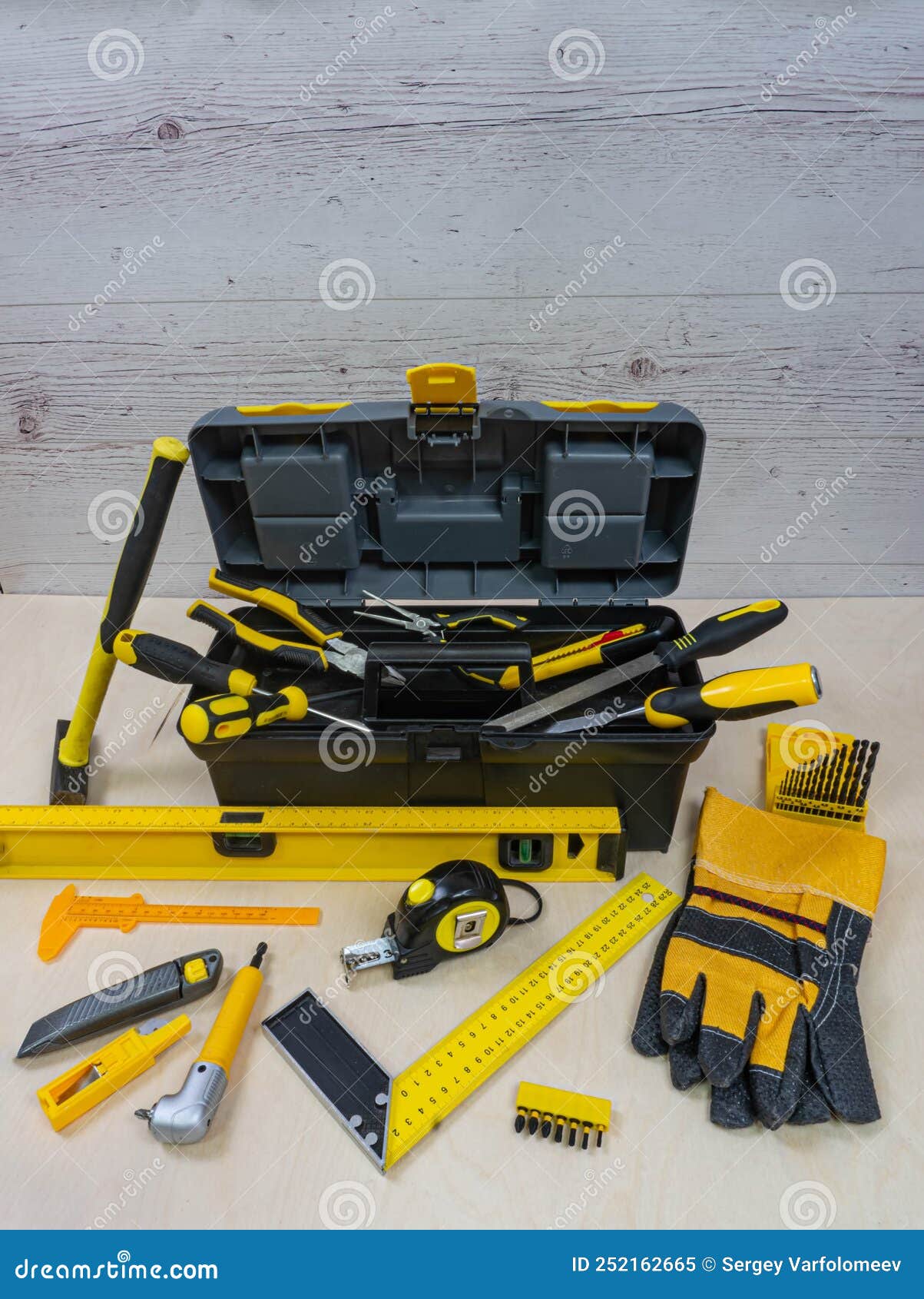 Yellow Construction Instruments and a Tool Box on a Wooden Background ...