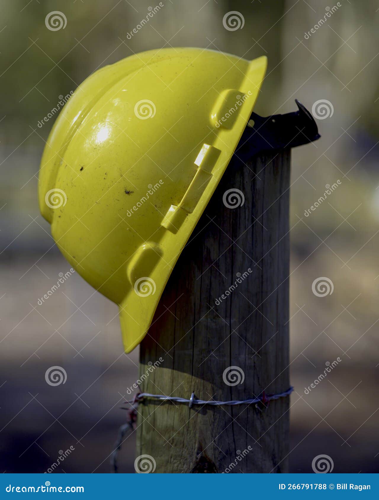 A Yellow Construction Workers Helmet on an Old Fence Post Stock Photo ...