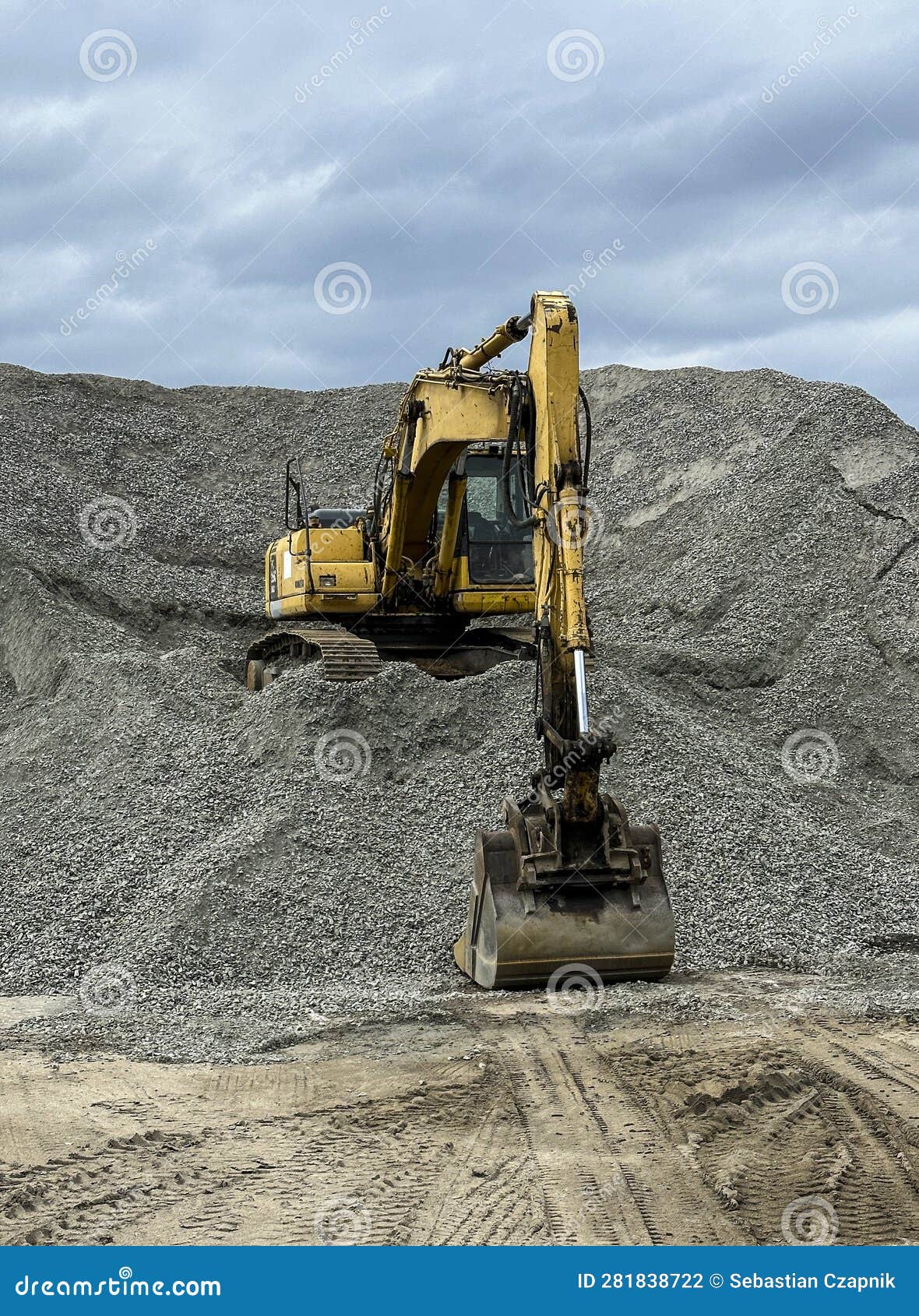 Yellow Digger Machine on Top of a Large Pile of Pebbles and Stones ...