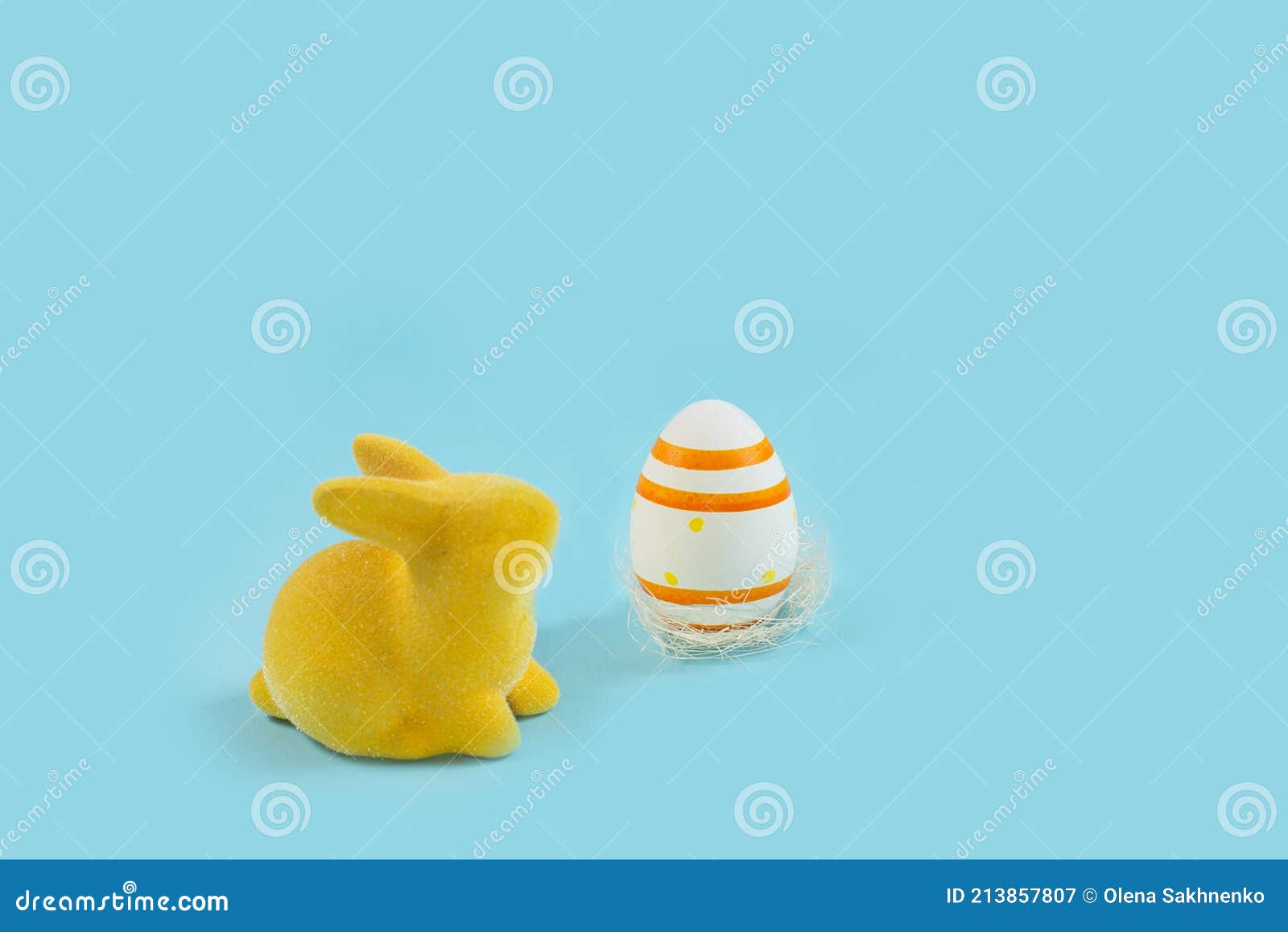 Yellow Easter Bunny Rabbit with Painted Egg on Blue Background. Stock ...