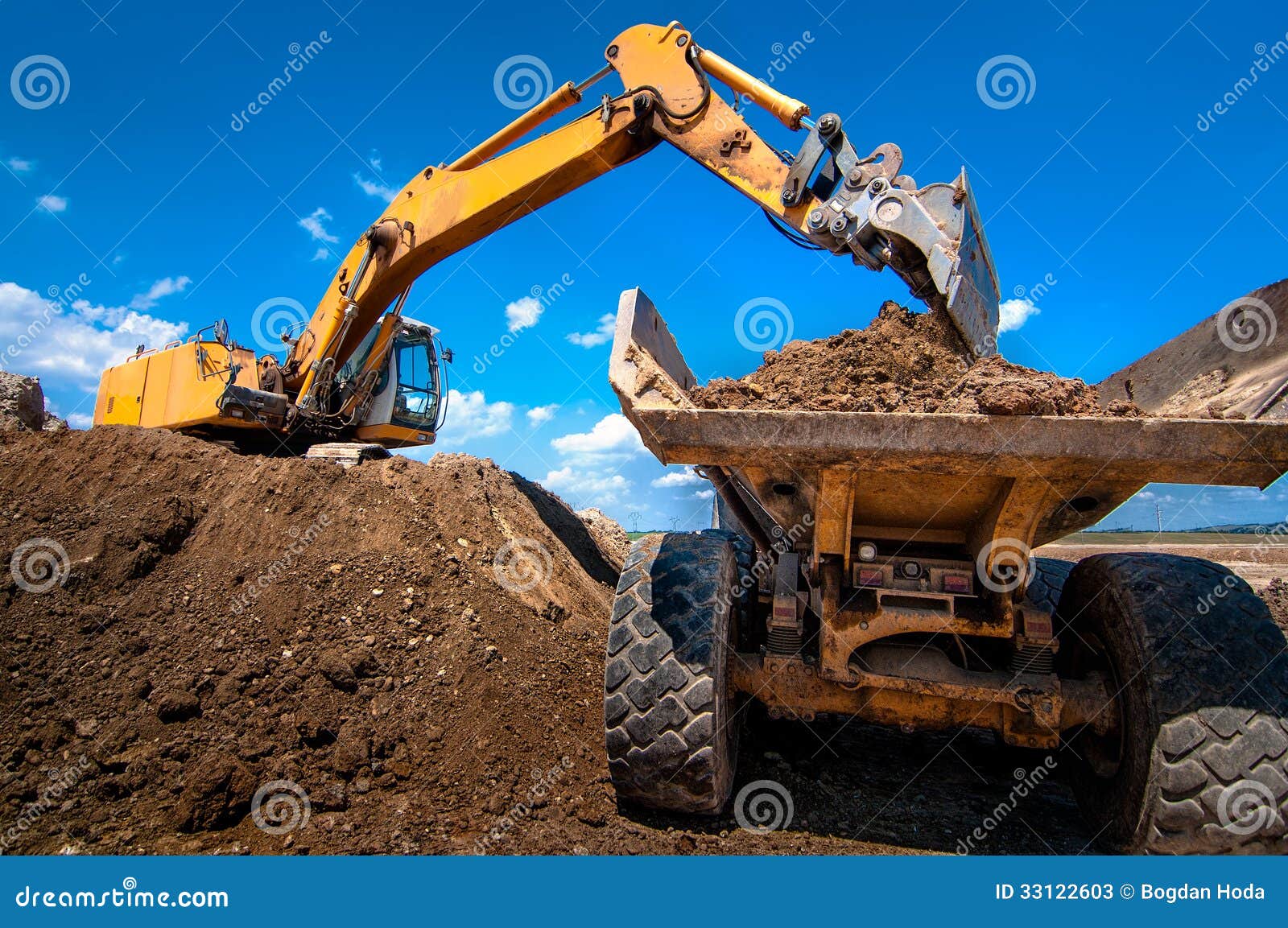 Yellow Excavator Loading Soil into a Dumper Truck Stock Image - Image ...