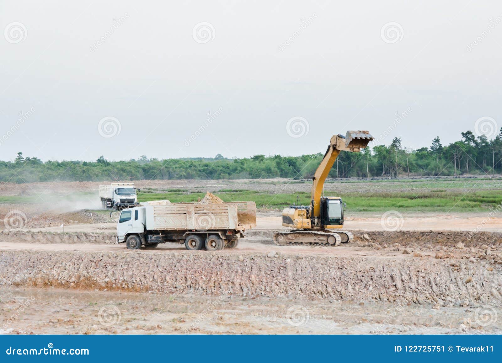 Yellow Excavator Machine Loading Soil into a Dump Truck at Construction ...