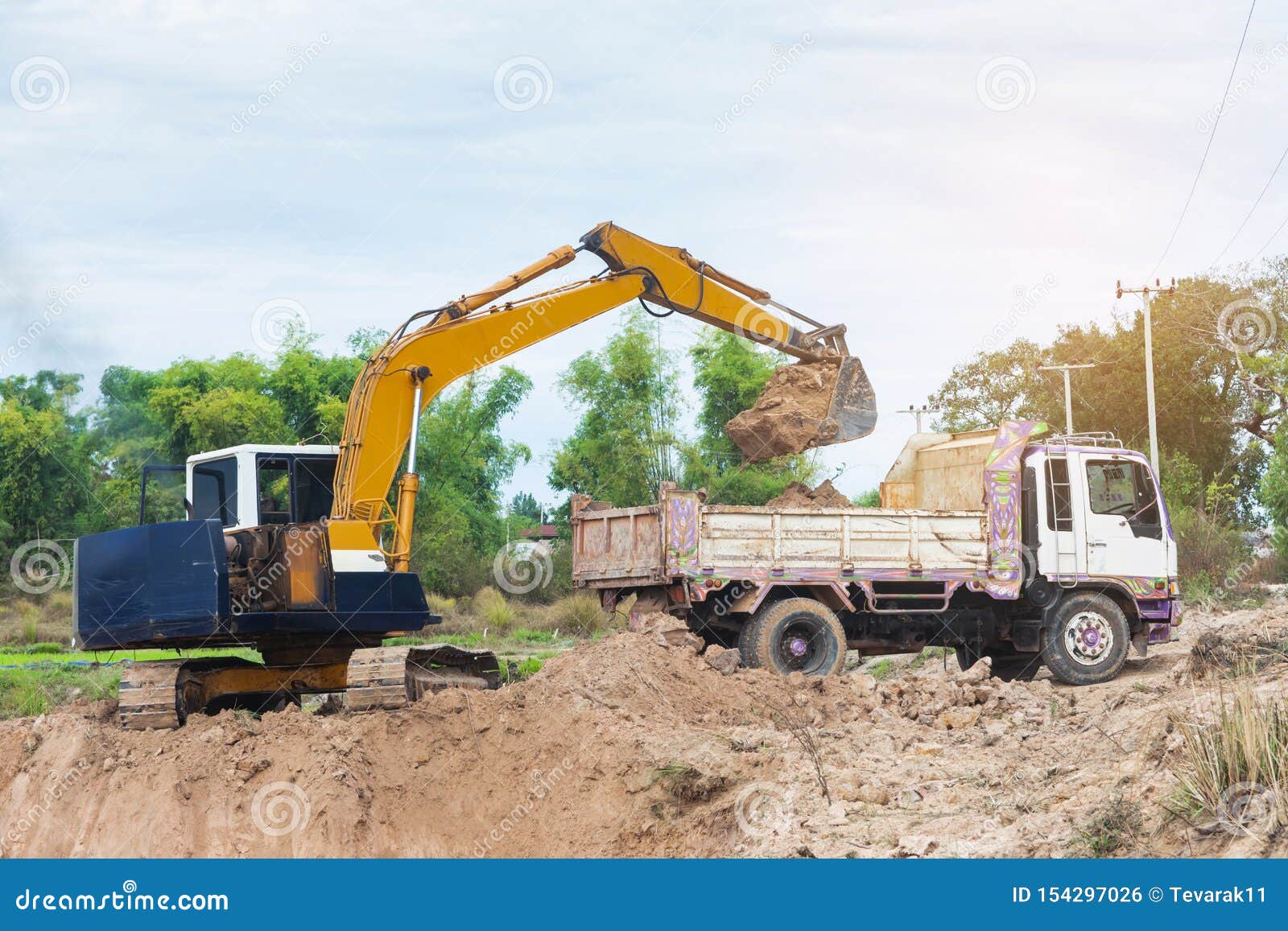 Yellow Excavator Machine Loading Soil into a Dump Truck at Construction ...