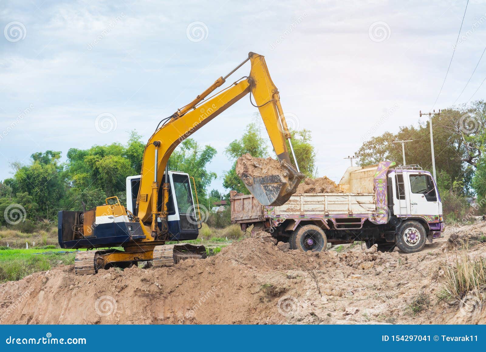 Yellow Excavator Machine Loading Soil into a Dump Truck at Construction ...