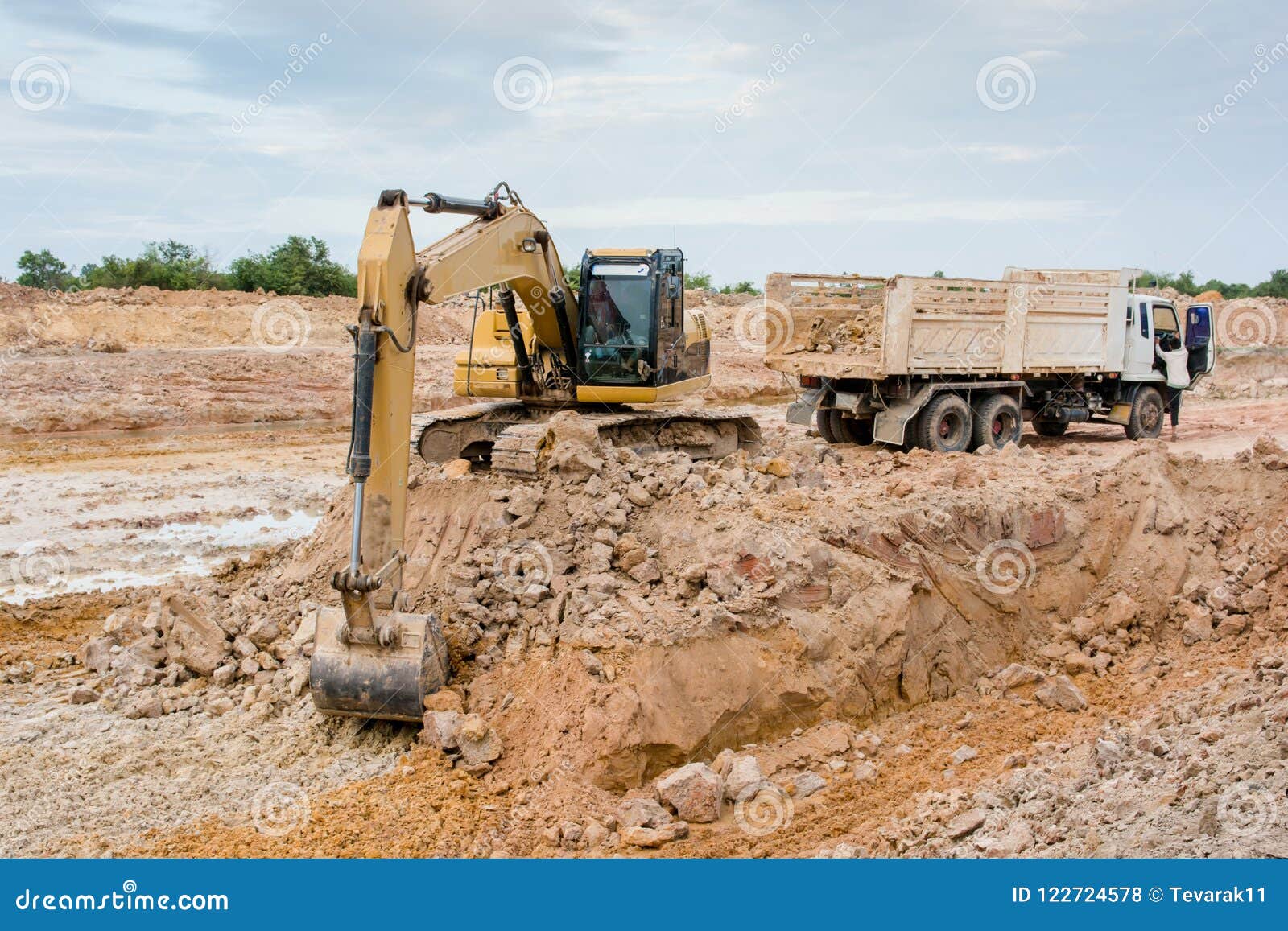 Yellow Excavator Machine Loading Soil into a Dump Truck at Construction ...