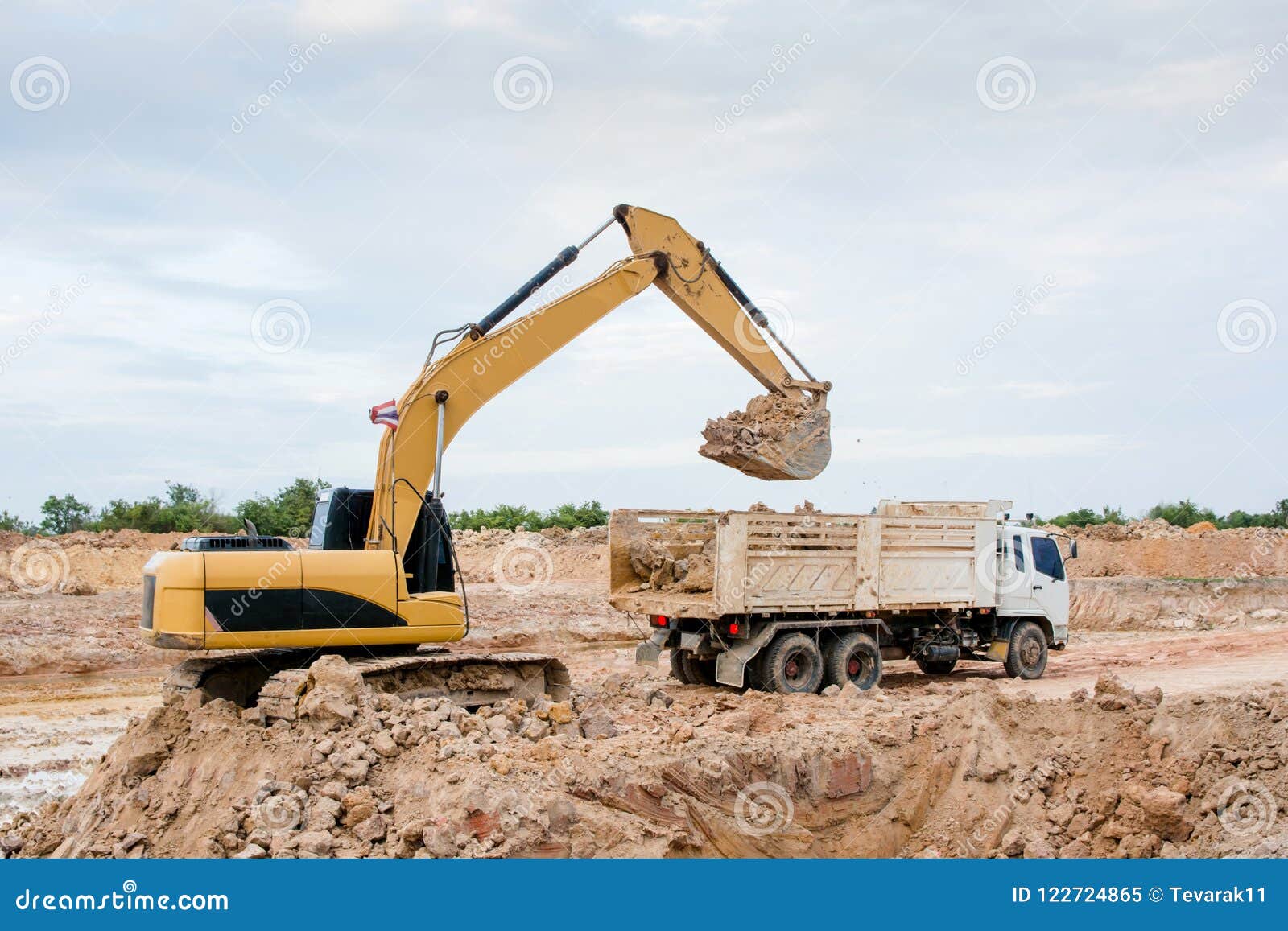 Yellow Excavator Machine Loading Soil into a Dump Truck at Construction ...