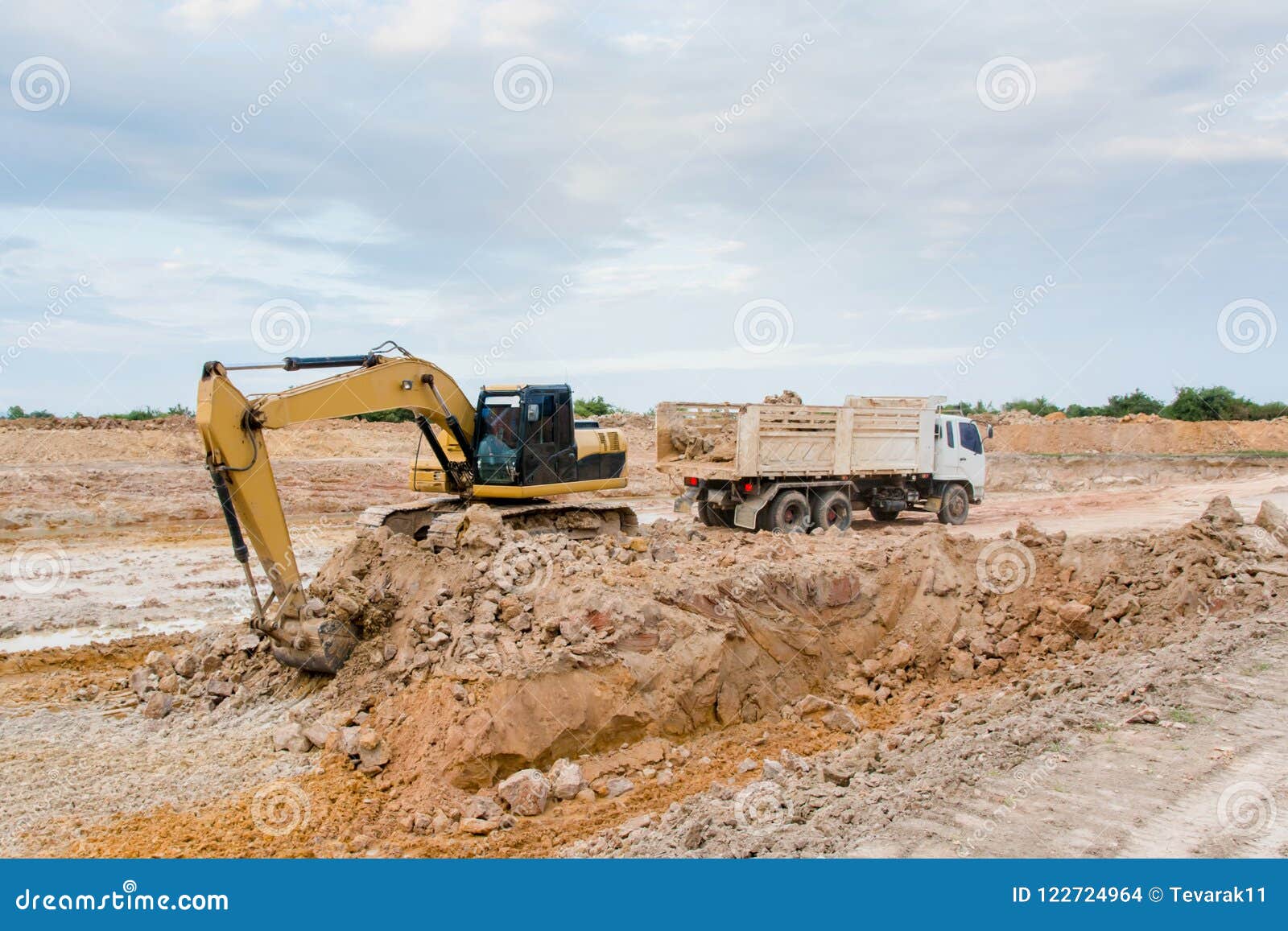 Yellow Excavator Machine Loading Soil into a Dump Truck at Construction ...