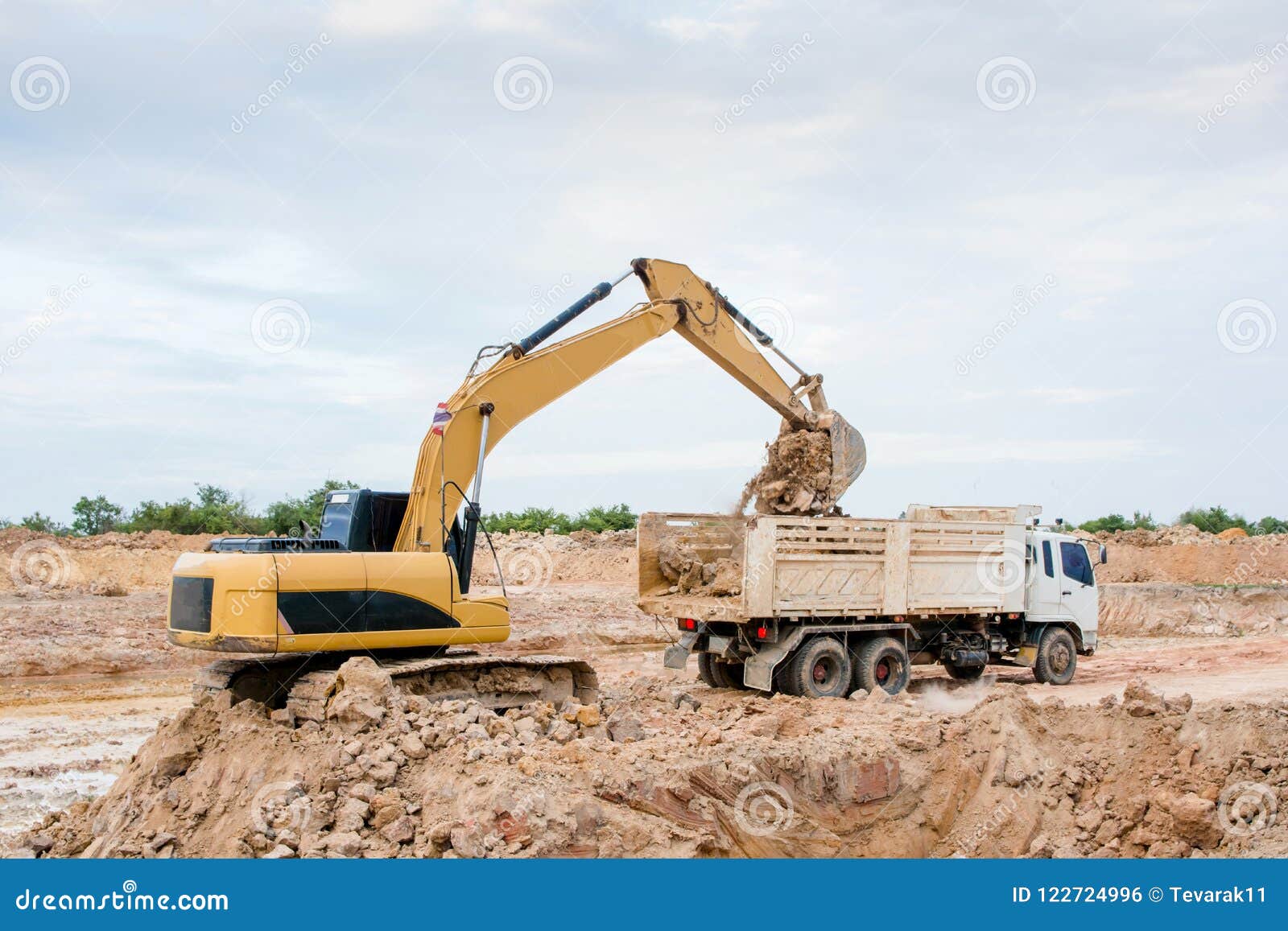 Yellow Excavator Machine Loading Soil into a Dump Truck at Construction ...