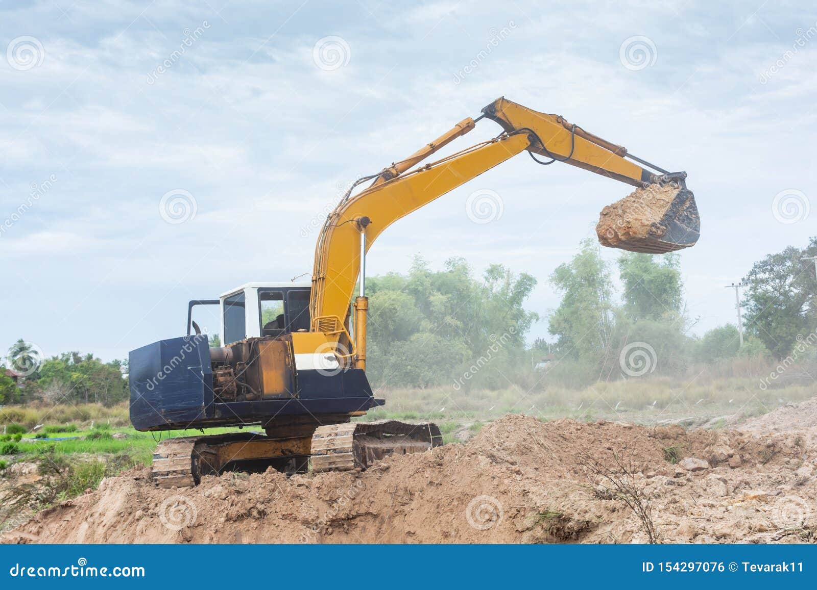 Yellow Excavator Machine Loading Soil into a Dump Truck at Construction ...