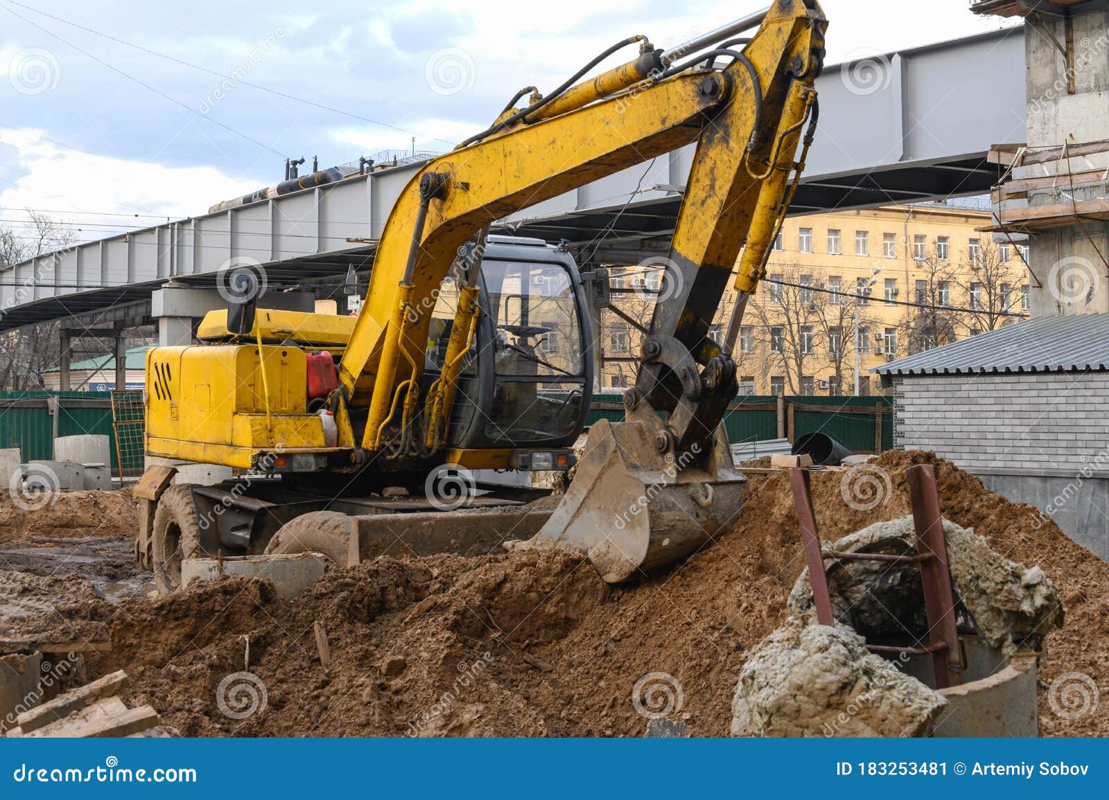 Yellow Excavator on Wheels Digs the Ground. Earthwork with an Excavator ...