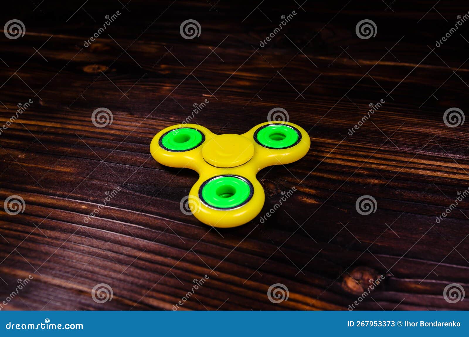 Yellow Fidget Spinner on Wooden Desk Stock Image - Image of hand ...