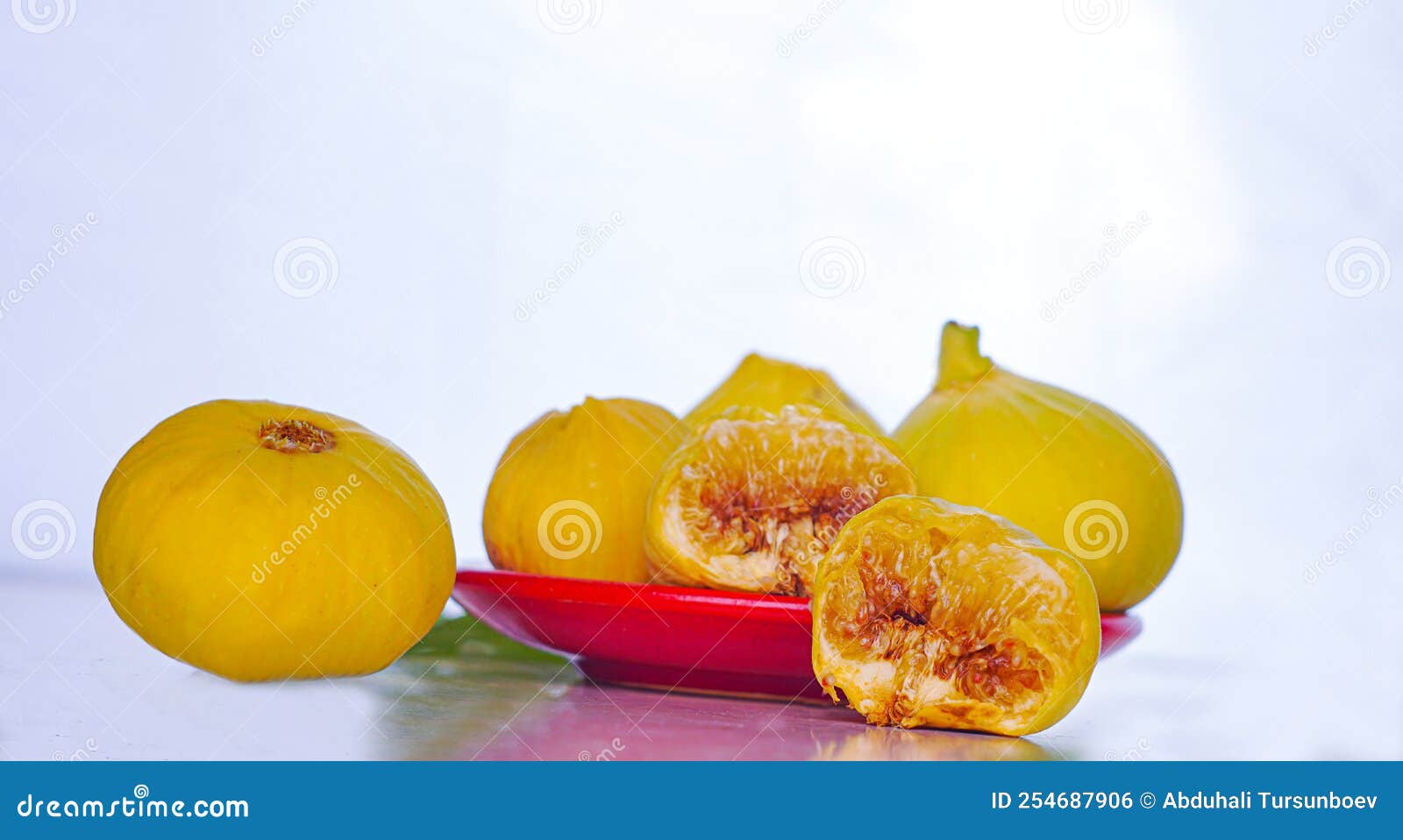 Yellow figs in a red bowl stock photo. Image of closeup - 254687906
