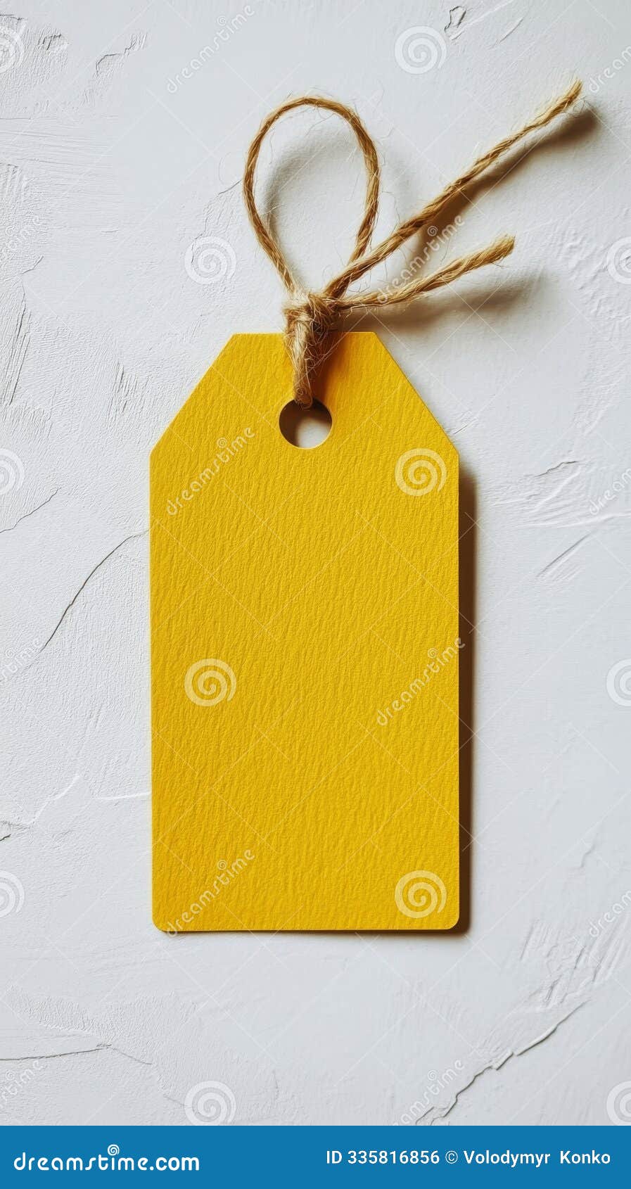 Yellow Gift Tag with Twine on Textured White Background Stock Photo ...