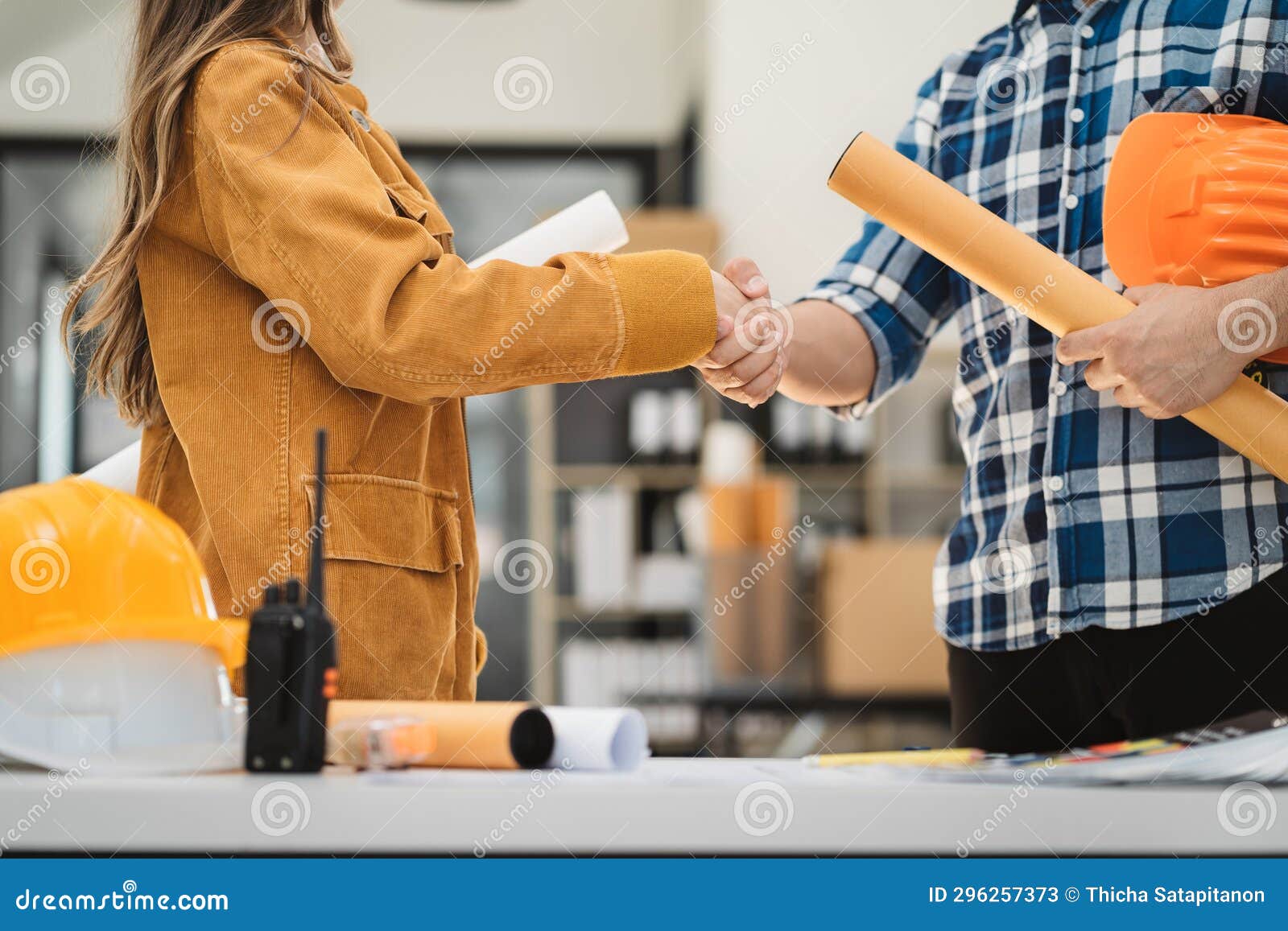 Yellow Hard Hat on Workbench with Construction Worker Hands Shaking Greeting Start Plan ...