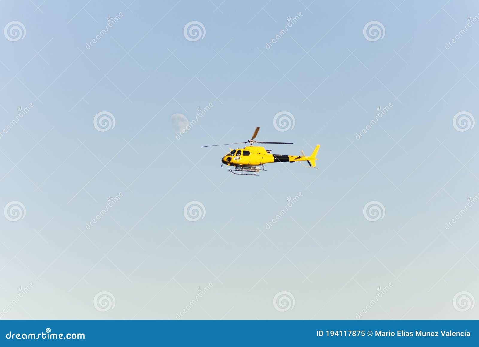 Yellow Helicopter Flying in the Blue Sky and the Moon Next To it during ...