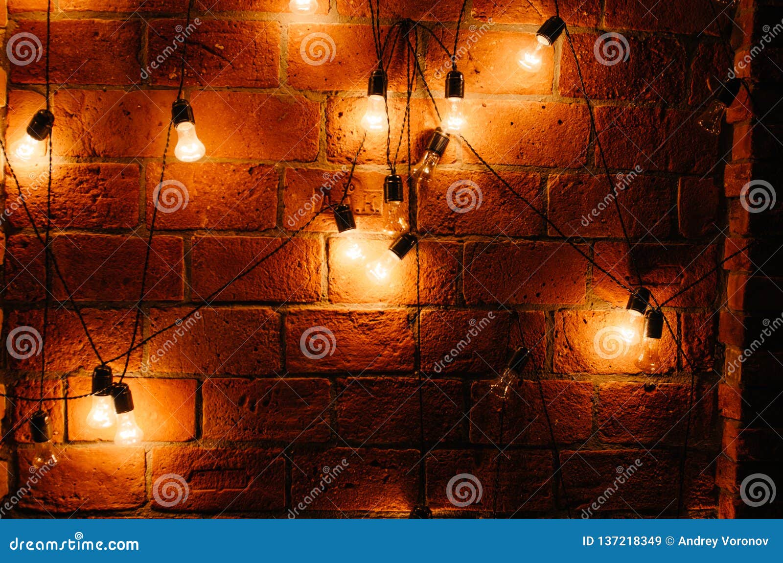 Yellow Light Bulbs with Black Wires on a Brick Wall Stock Image - Image ...