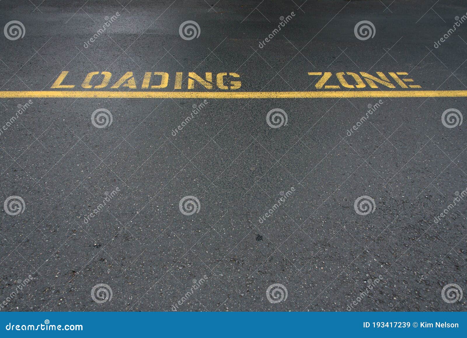 Yellow Line and Loading Zone Text on an Asphalt Street Stock Image ...