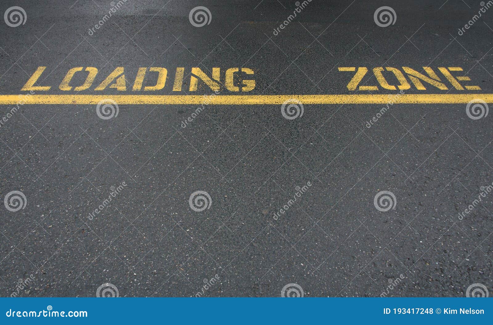 Yellow Line and Loading Zone Text on an Asphalt Street Stock Photo ...