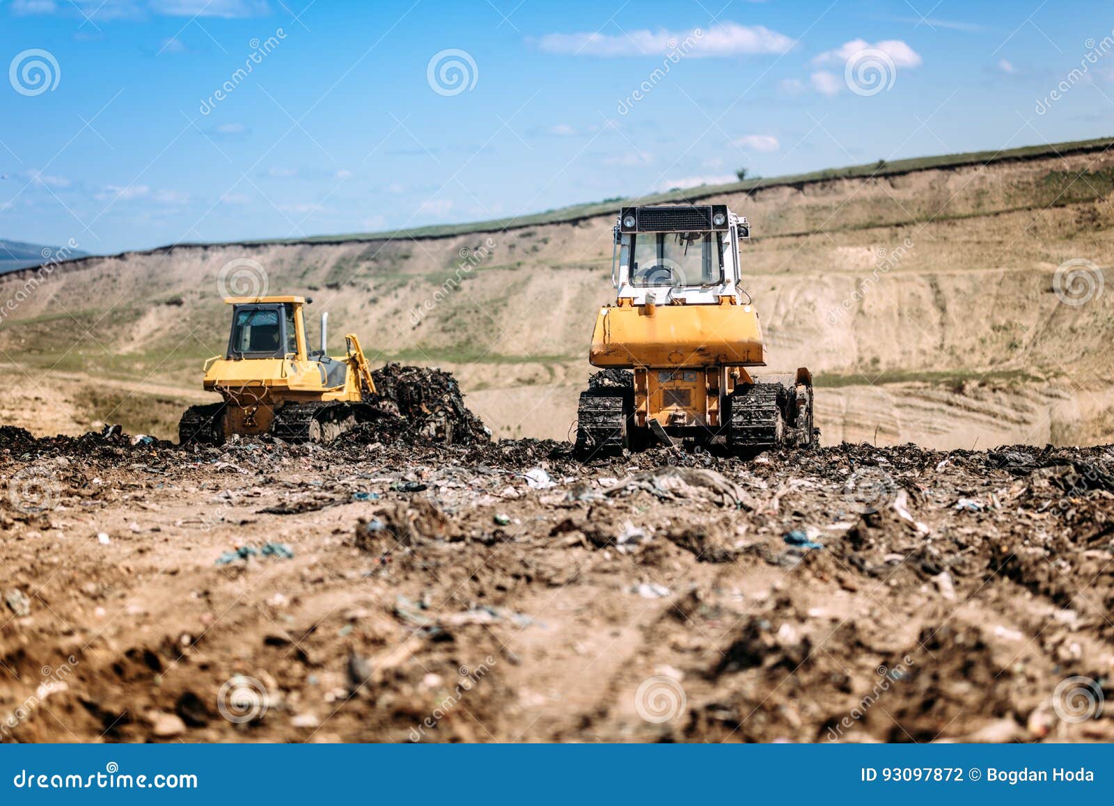 Yellow Mini Bulldozers Working and Moving Garbage on Dumping Site Stock ...
